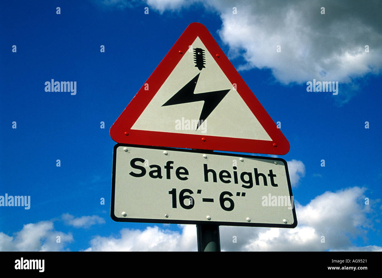 Overhead electricity live wires warning sign at railway level crossing ...