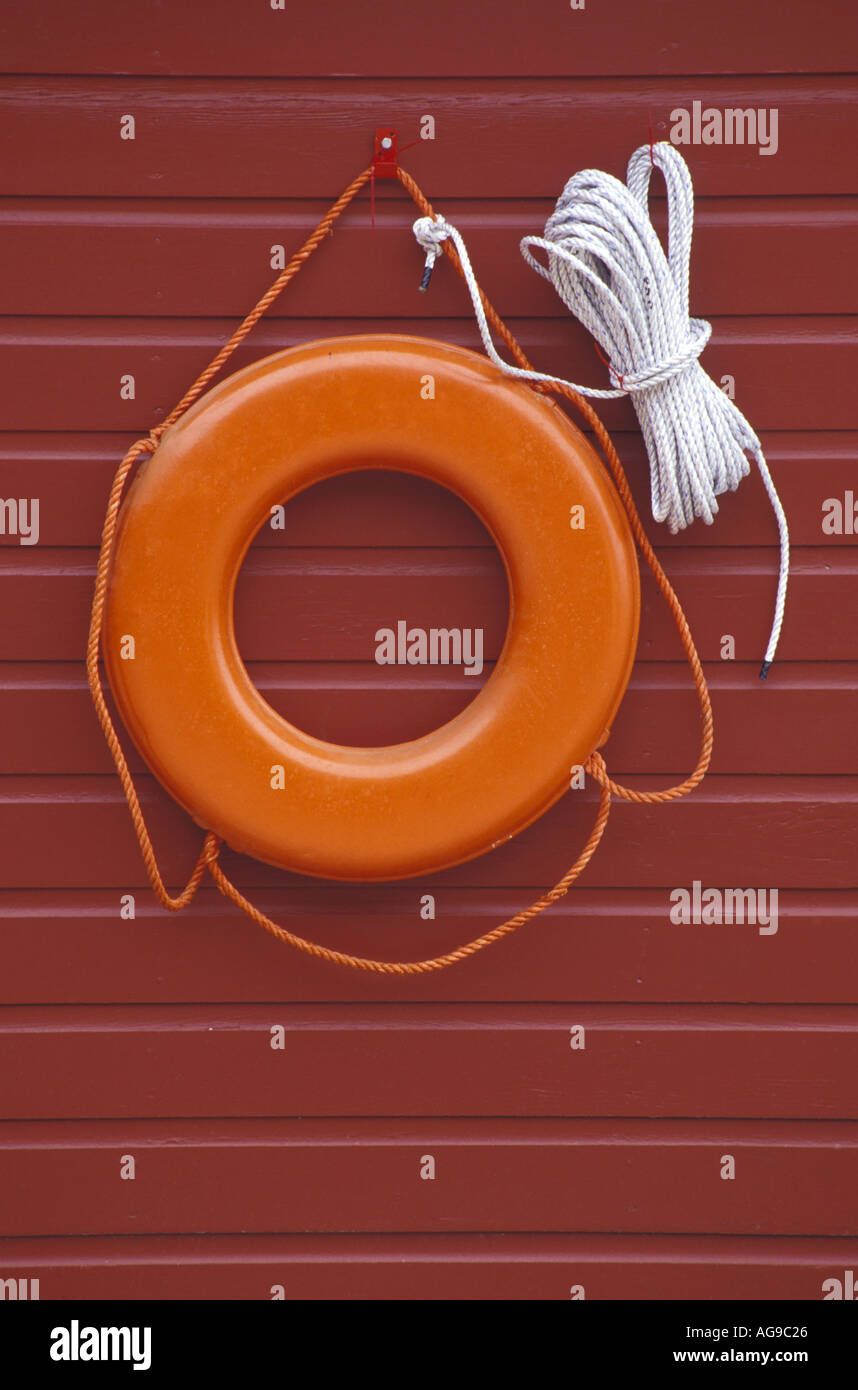 Life ring hanging on red wall Stock Photo - Alamy