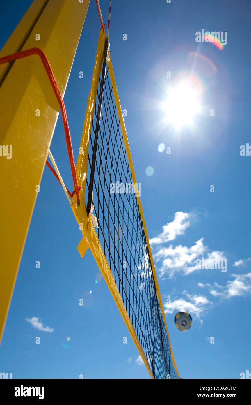 Ball flys over a Yellow Volleyball Footvolley Net against a blue sky ...