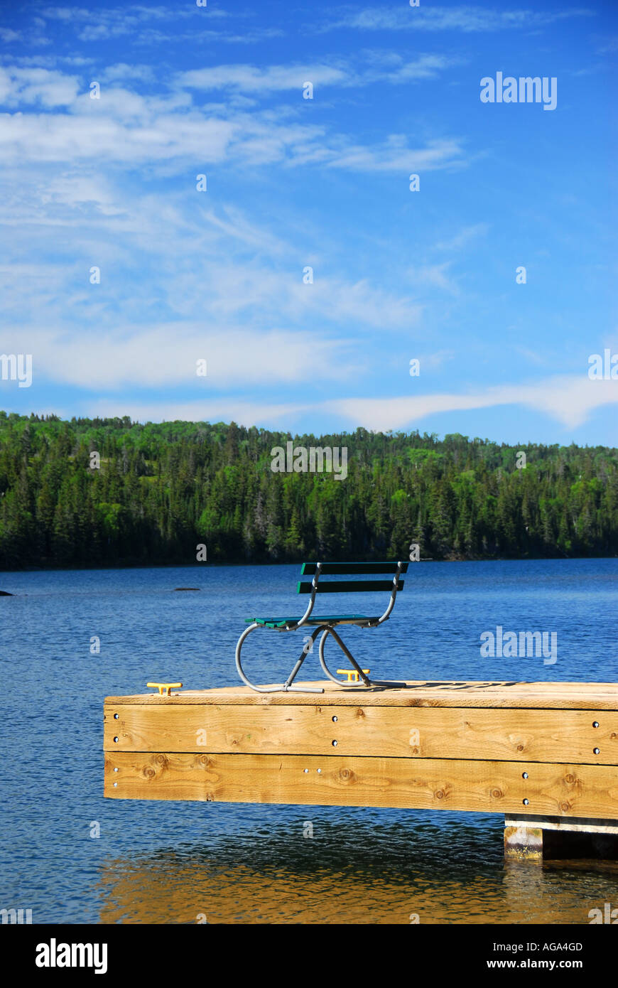 Empty bench on wood dock facing blue water Stock Photo - Alamy