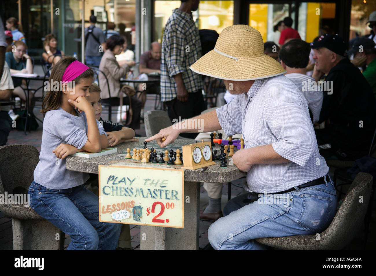 Chess master teaching children the game of chess at outdoor table at ...