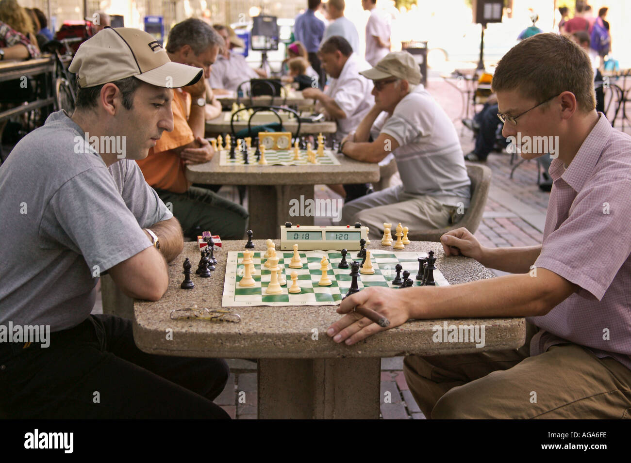 Men playing chess in Harvard Square on stone tables in plaza across ...