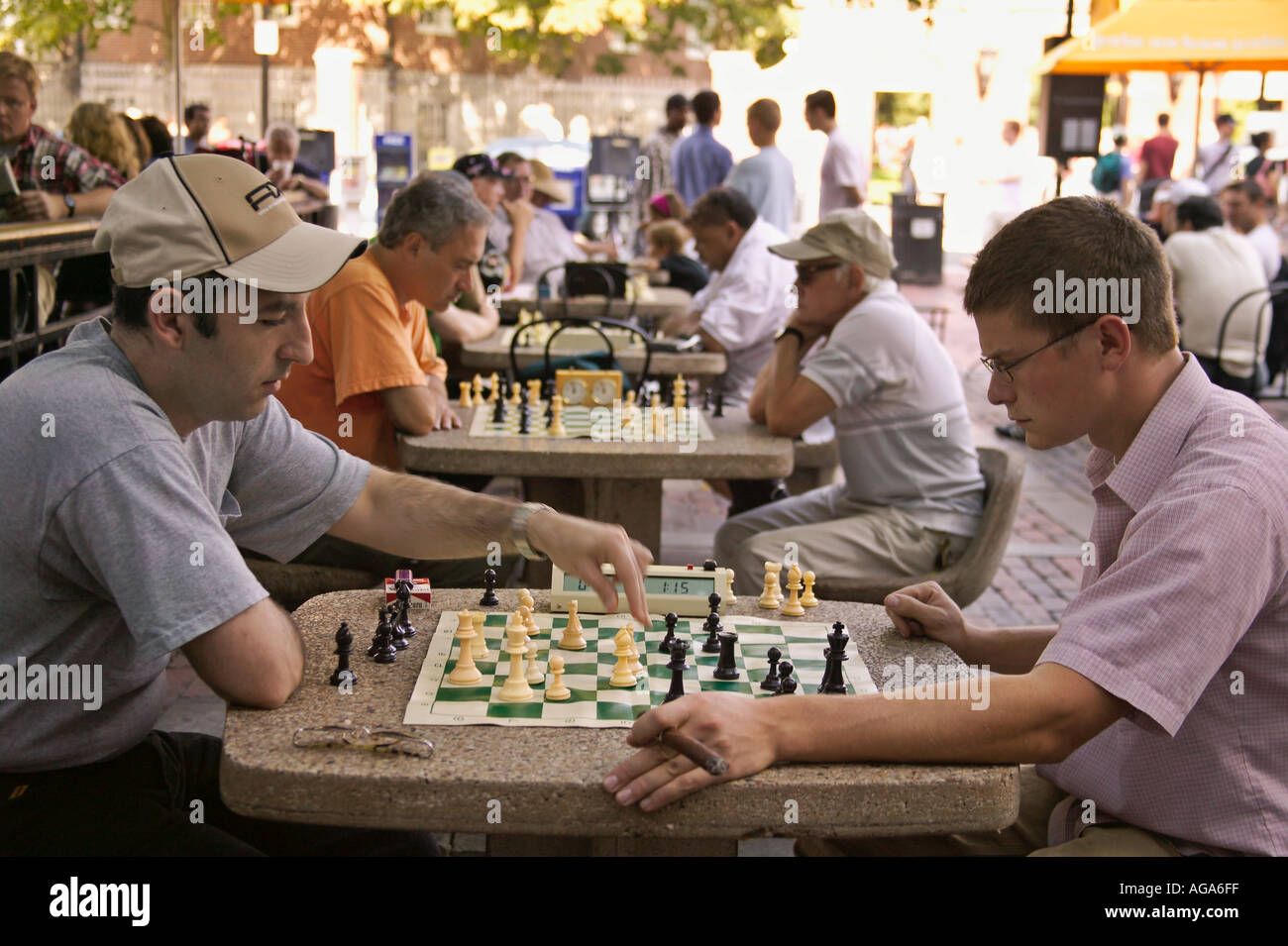 People playing chess in Harvard Square on stone tables in plaza across ...