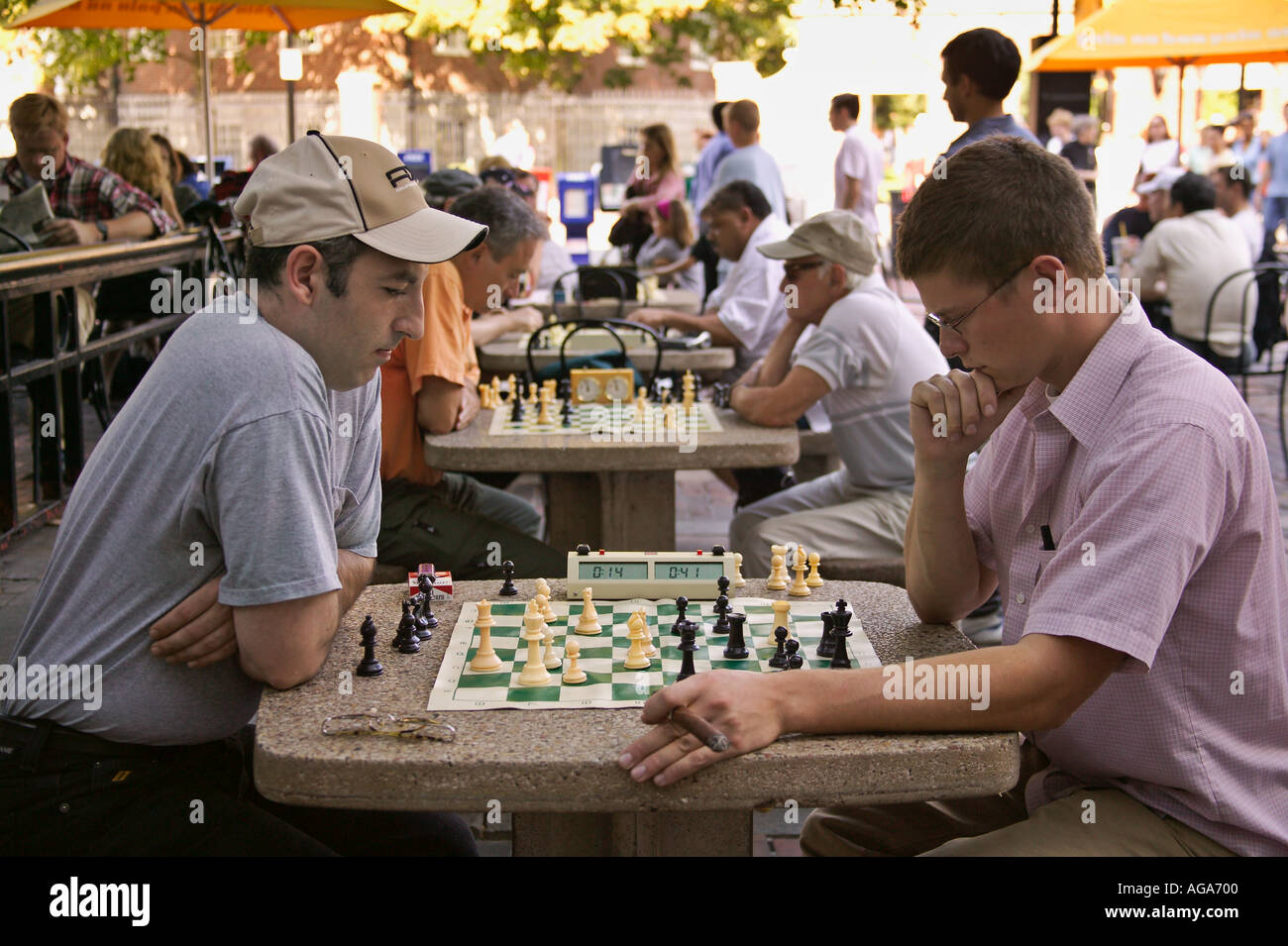 Men playing chess in Harvard Square on stone tables in plaza across ...