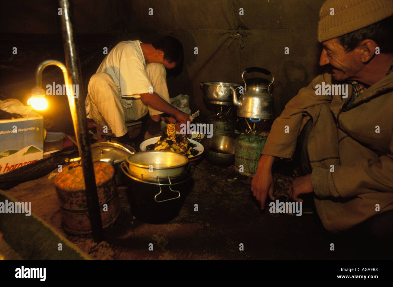 The cook making food inside the kitchen tent during a trek with mules ...