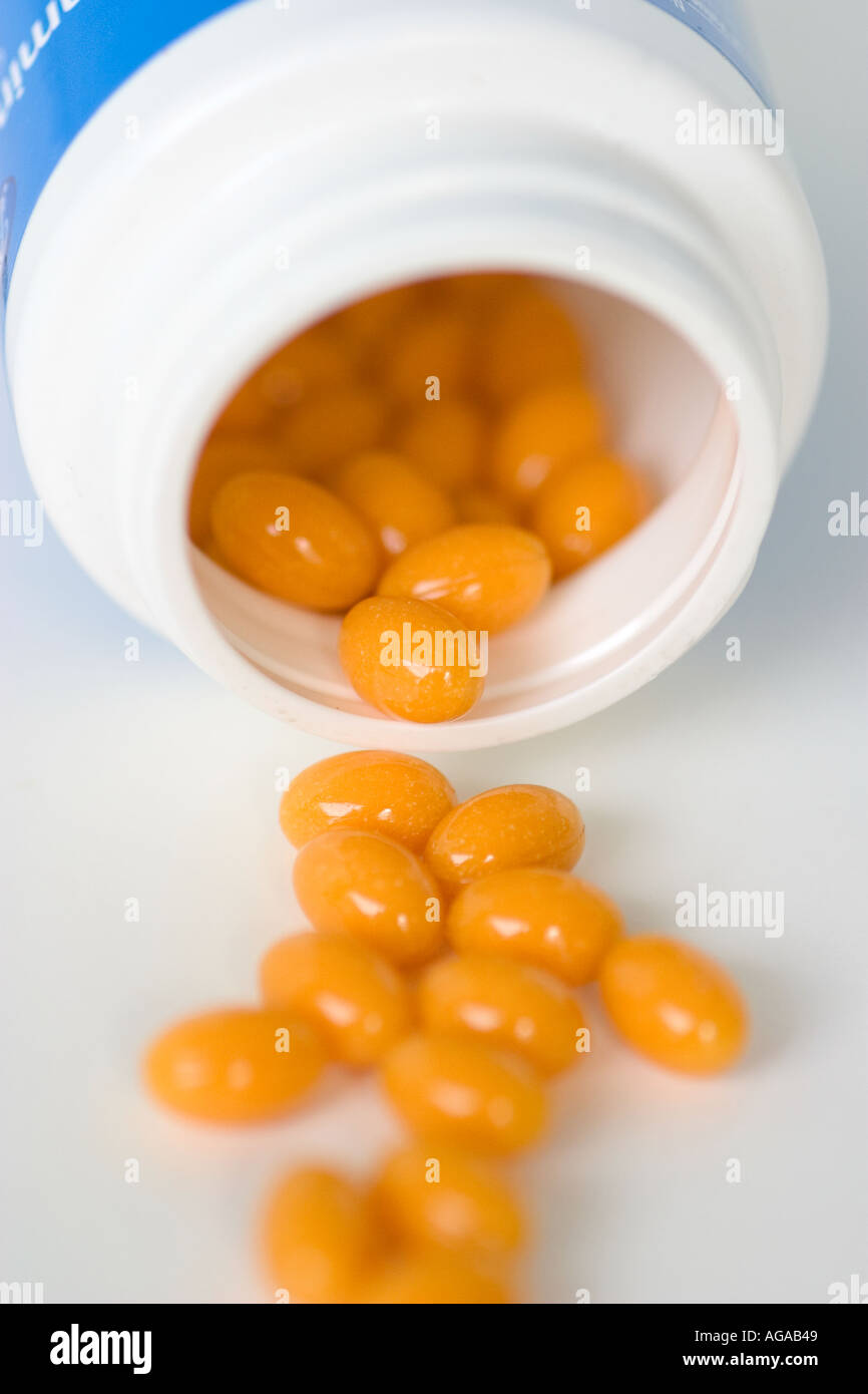 Yellow Vitamin Pills Spilling from Open Container Stock Photo - Alamy