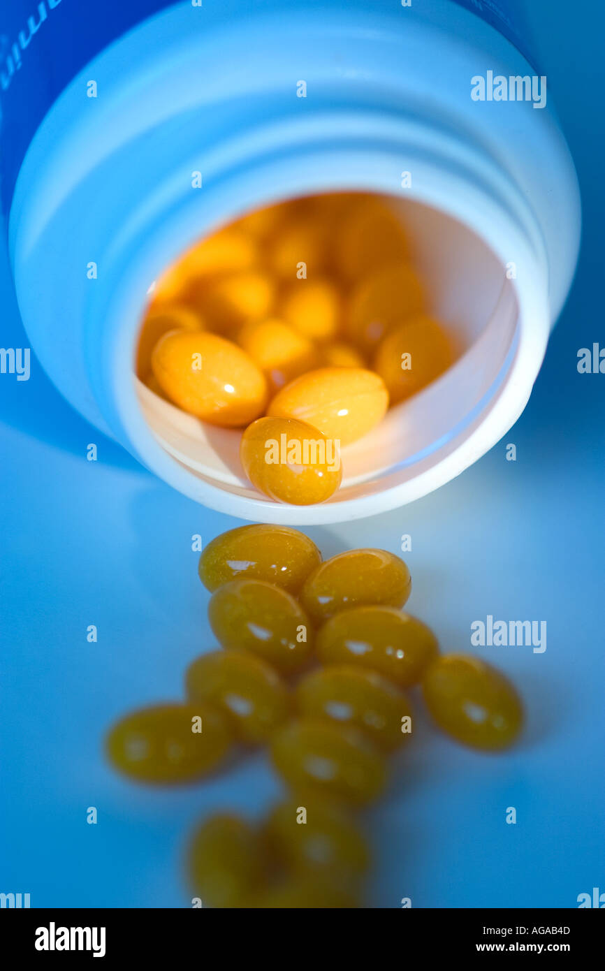 Yellow Vitamin Pills Spilling from Open Container Stock Photo - Alamy