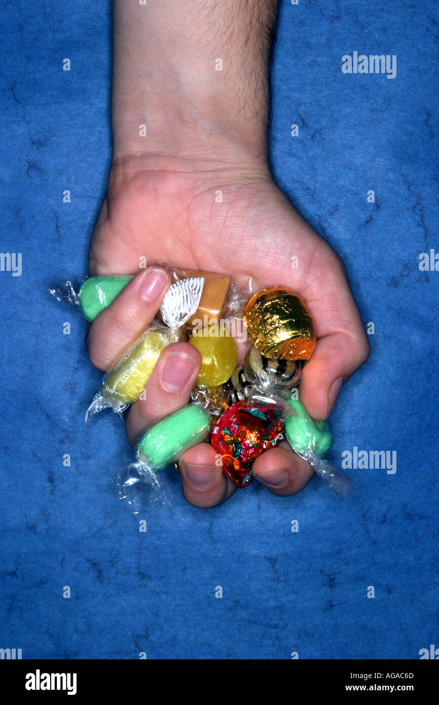 Man s hand holding sweets Stock Photo - Alamy