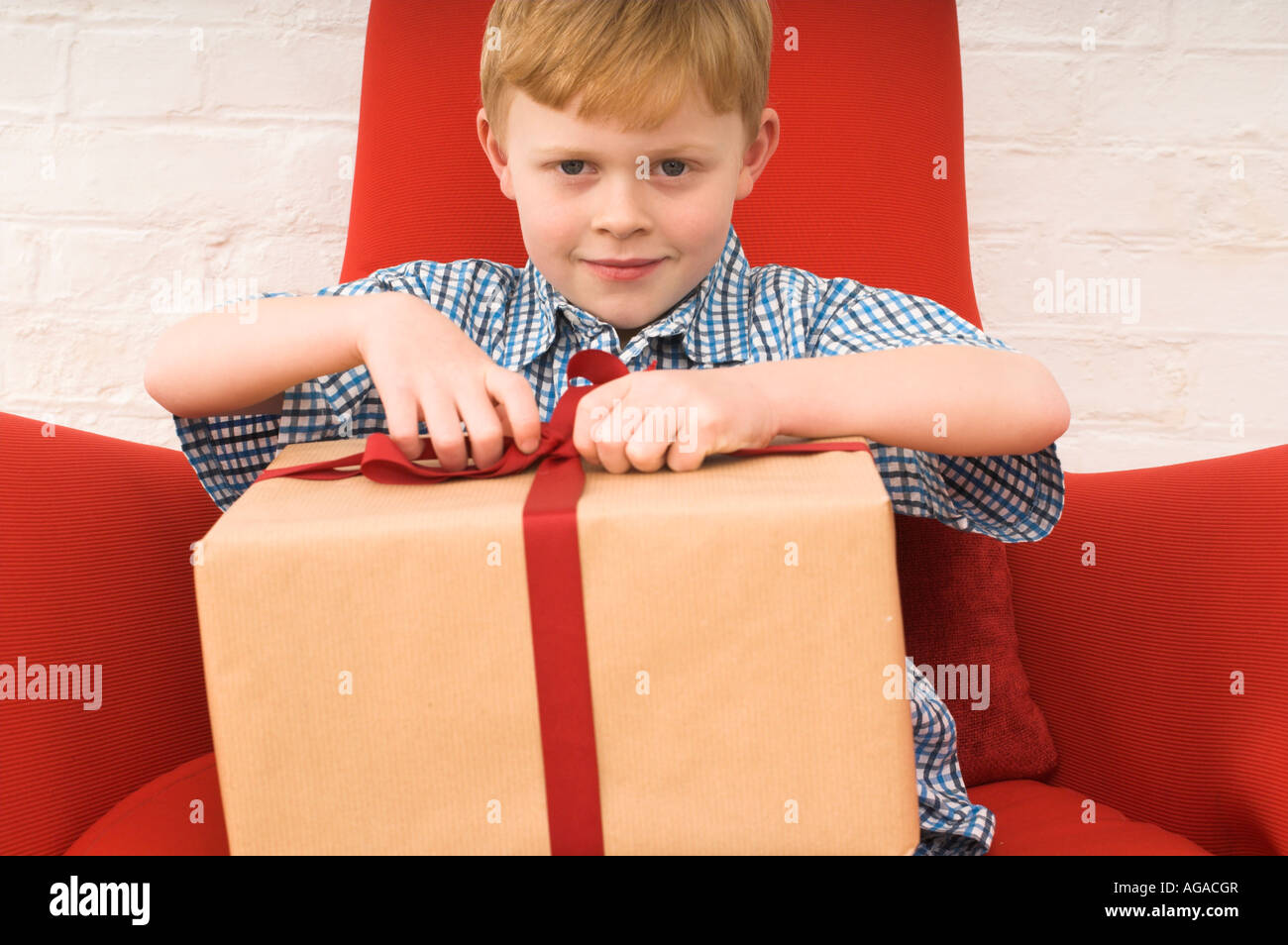 red haired boy trying to open present Stock Photo - Alamy