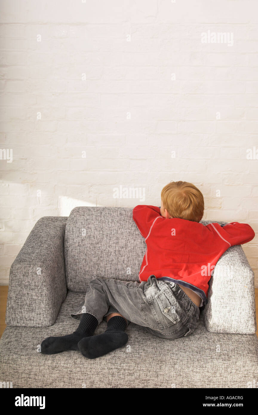 rear view of young boy sitting in arm chair Stock Photo - Alamy