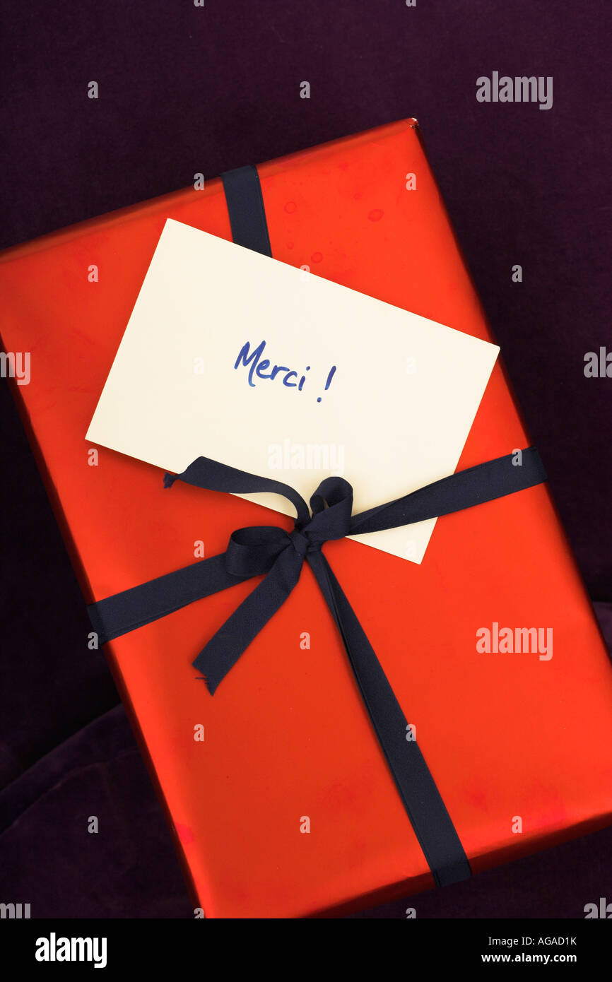 close-up of red present with french note merci Stock Photo - Alamy