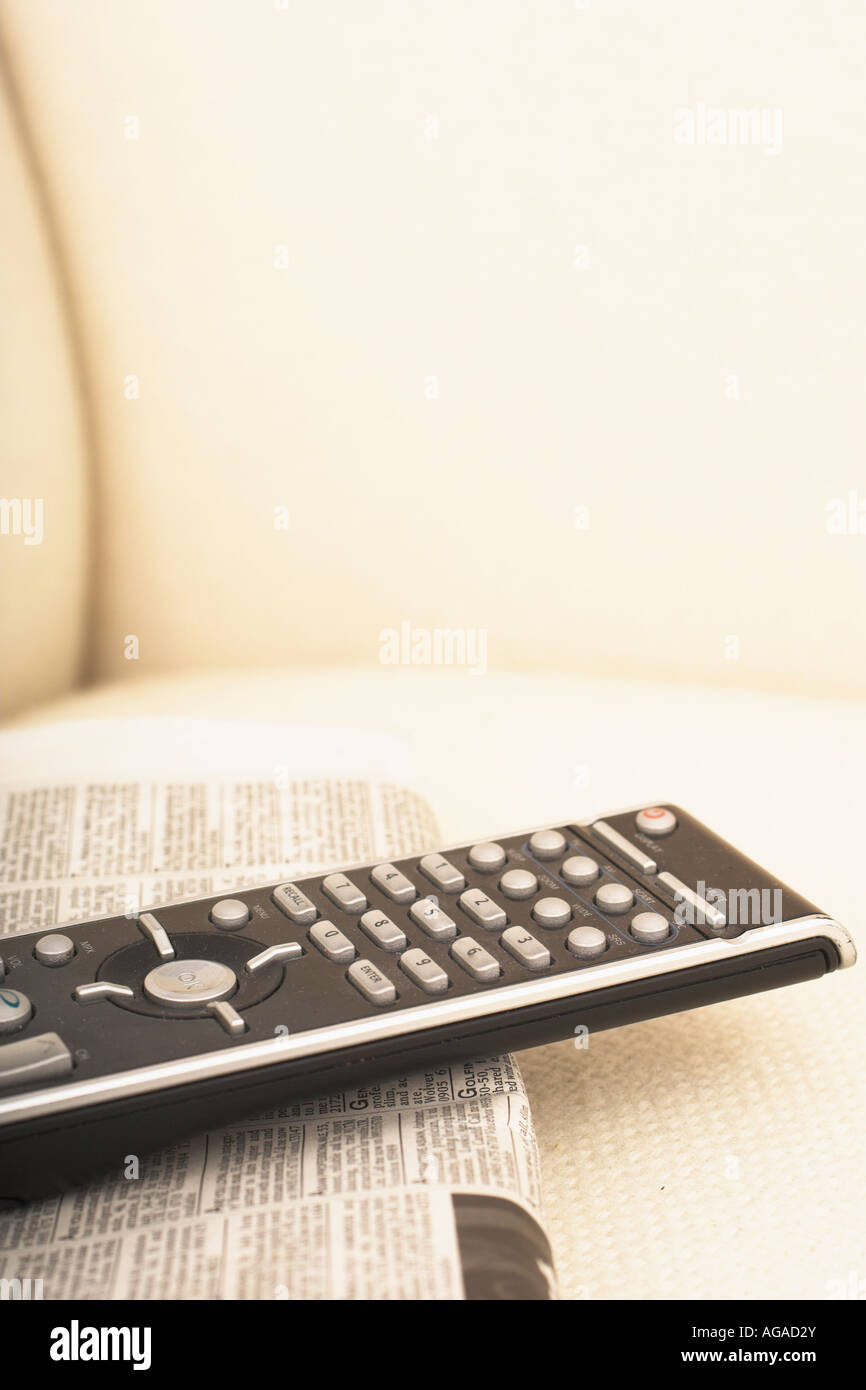 close-up of newspaper and remote control on arm chair Stock Photo - Alamy