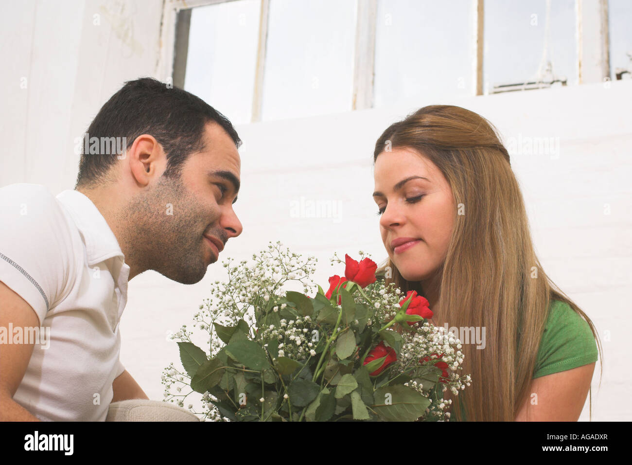 young woman giving young woman bouquet of red roses Stock Photo - Alamy