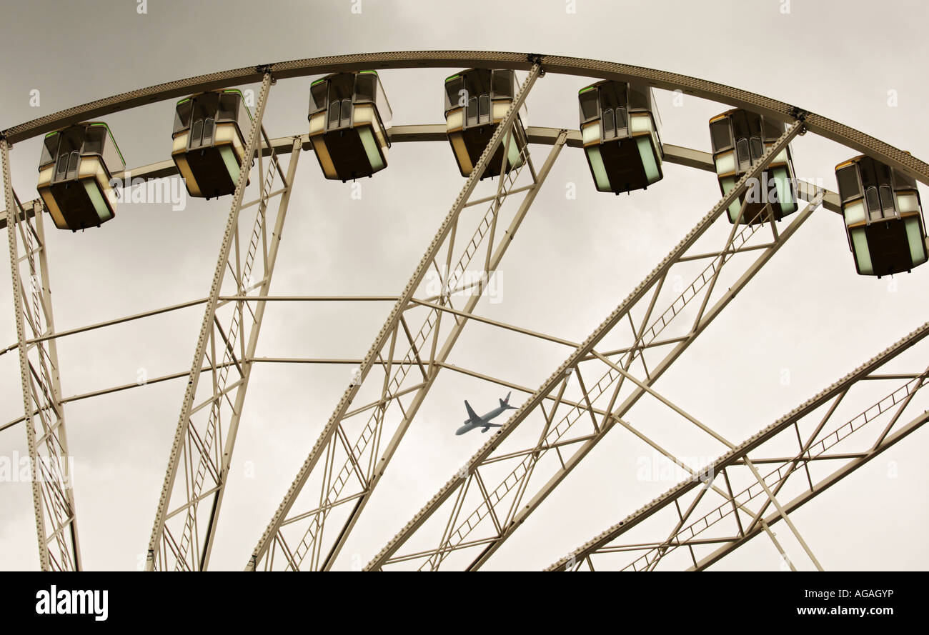 Ferris wheel rotating with airplane flying in background Stock Photo ...