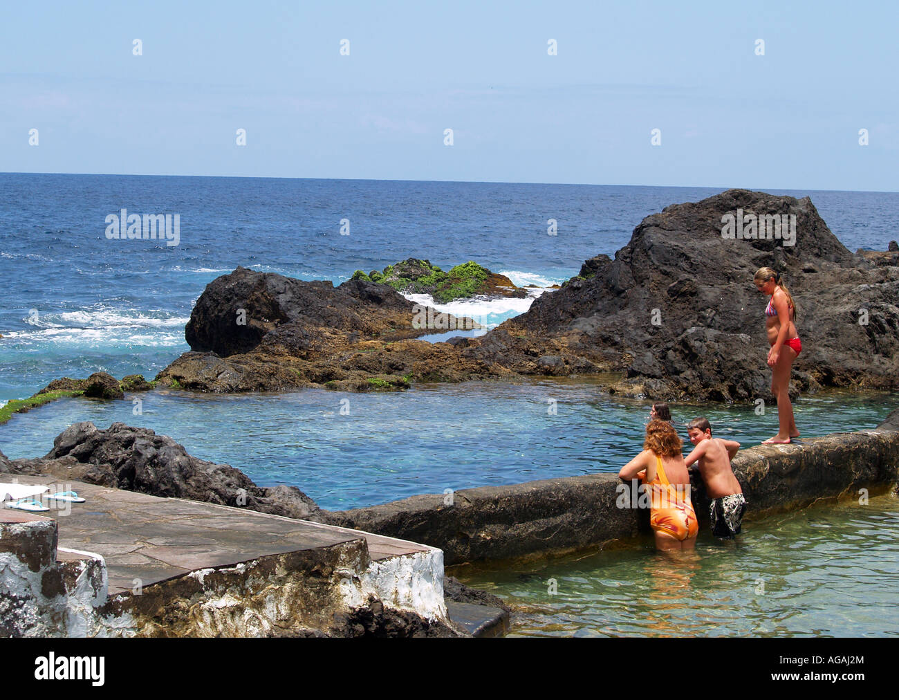 People bathing in natural rock pools on the coast of Garachico ...