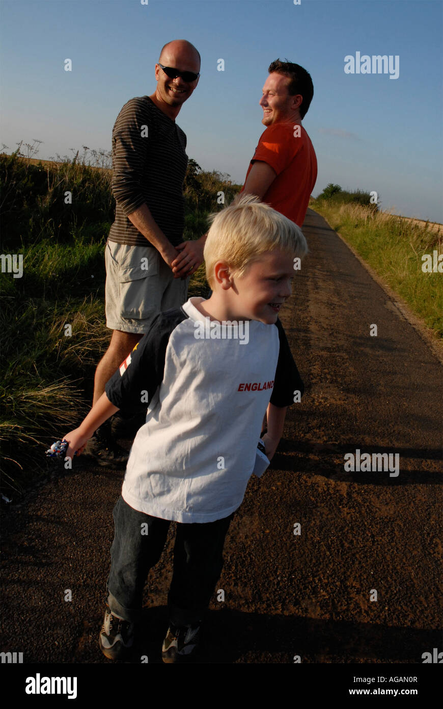 Two men and a little boy standing on a country road Stock Photo - Alamy
