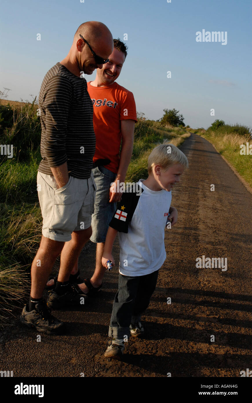Two men and a little boy standing on a country road Stock Photo - Alamy