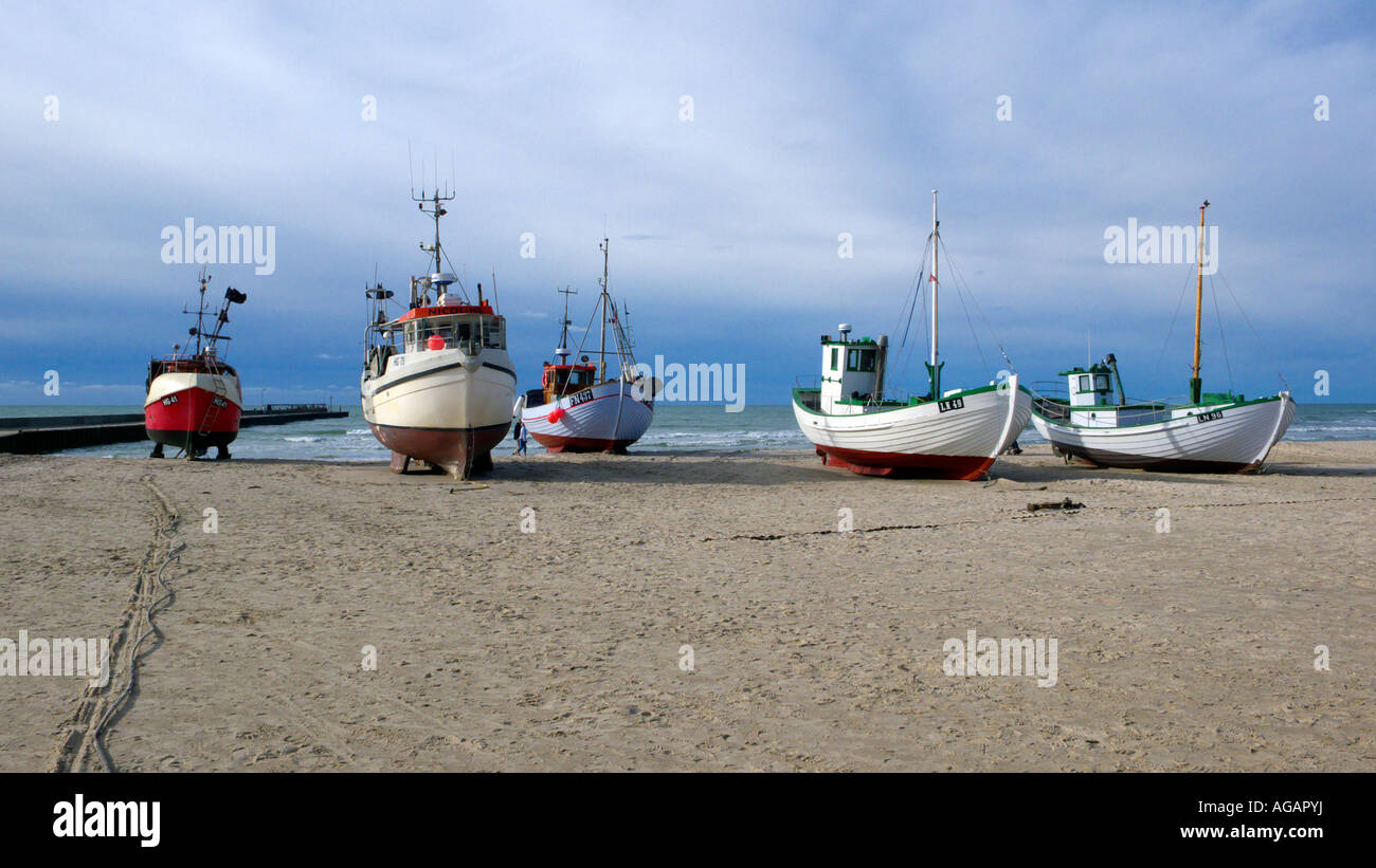Five Danish fishing boats beached on the sand at the sea side in Lokken ...
