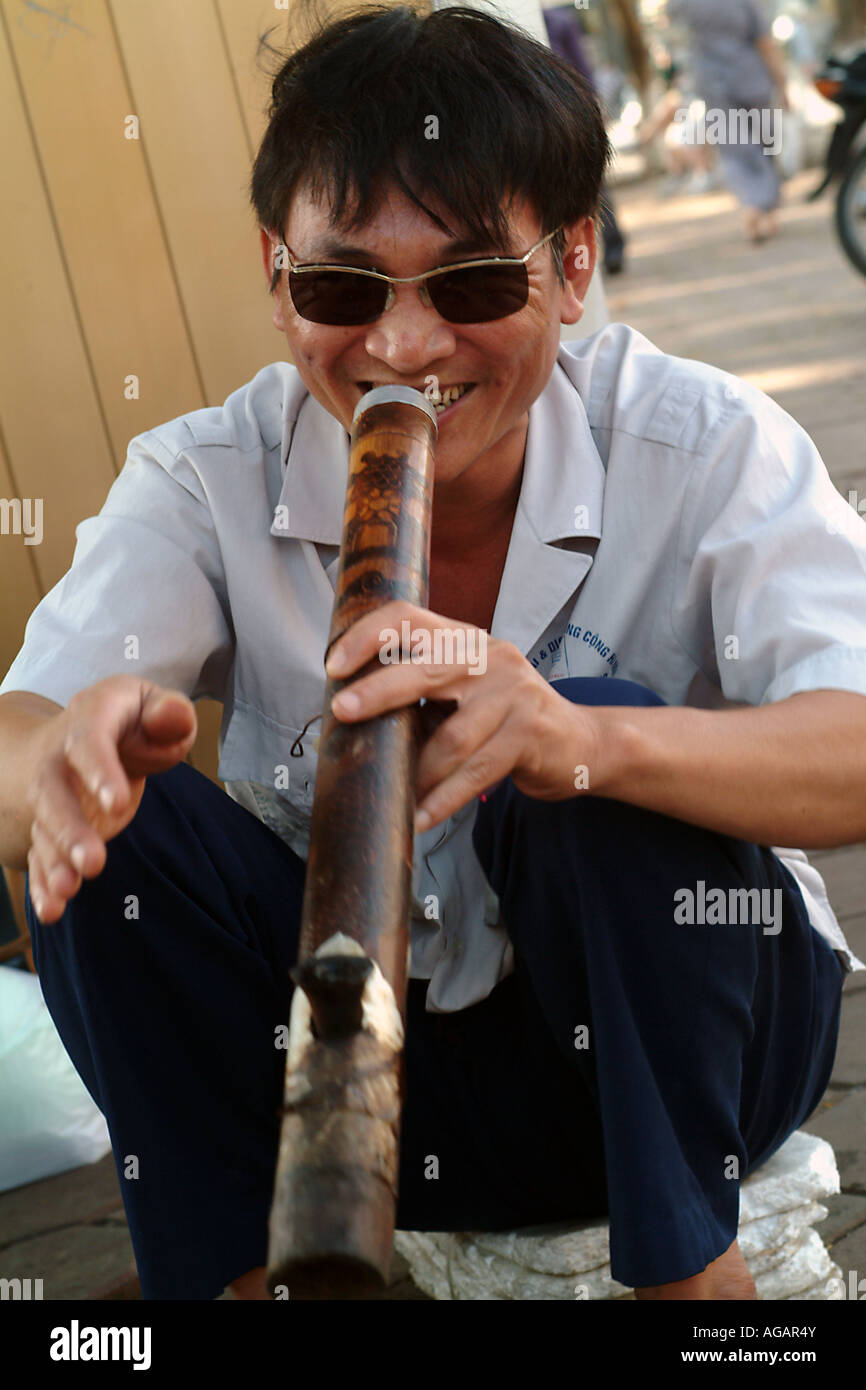 Vietnamese man smokes tobacco through a traditional pipe in central ...