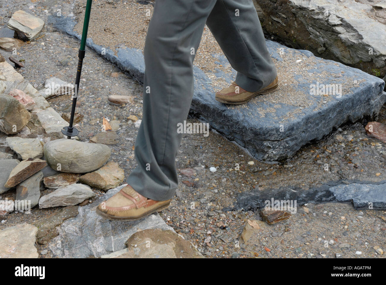 Close up of legs walking over rocky and rugged terrain Stock Photo - Alamy