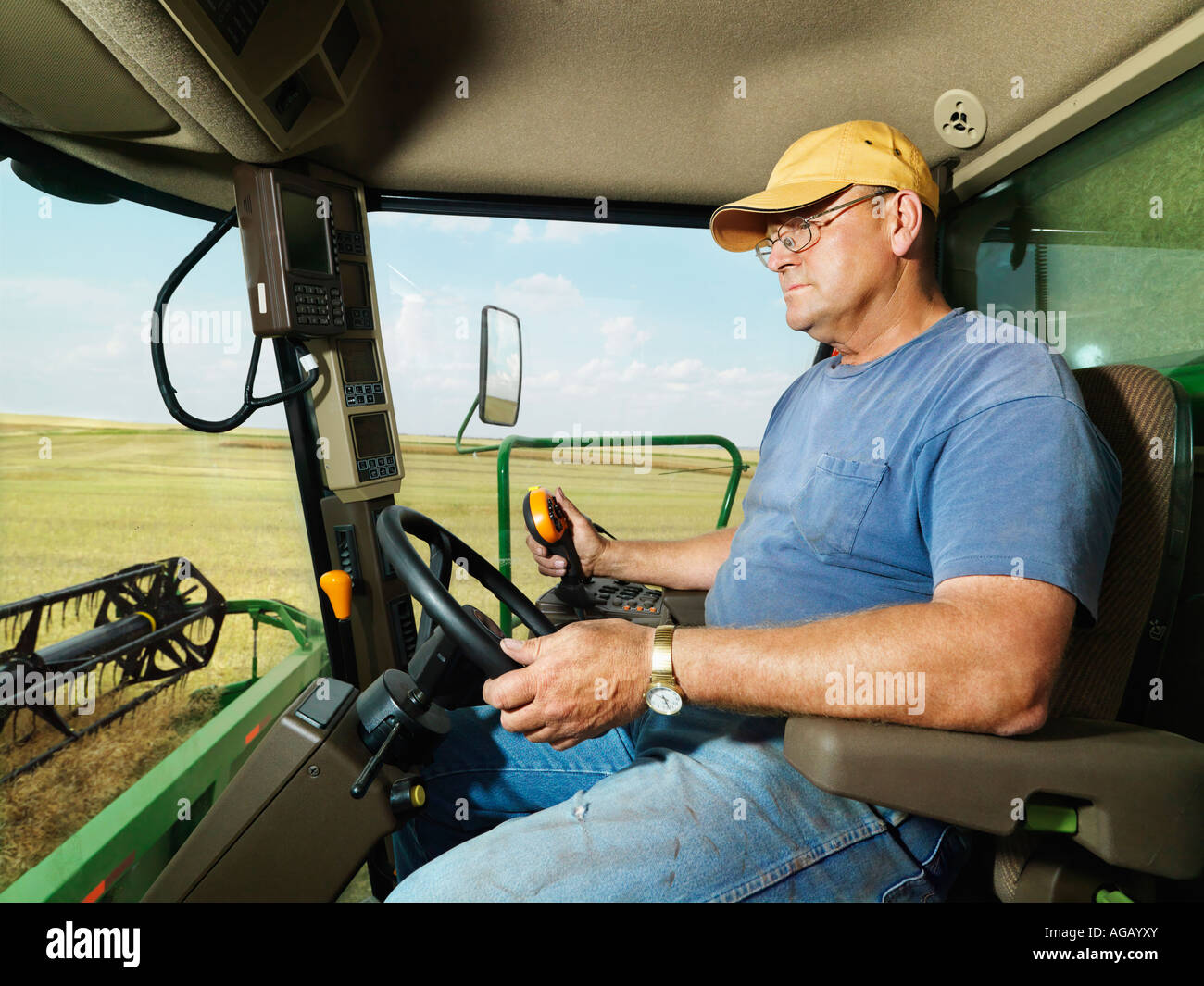 Farmer driving combine and harvesting crop Stock Photo - Alamy