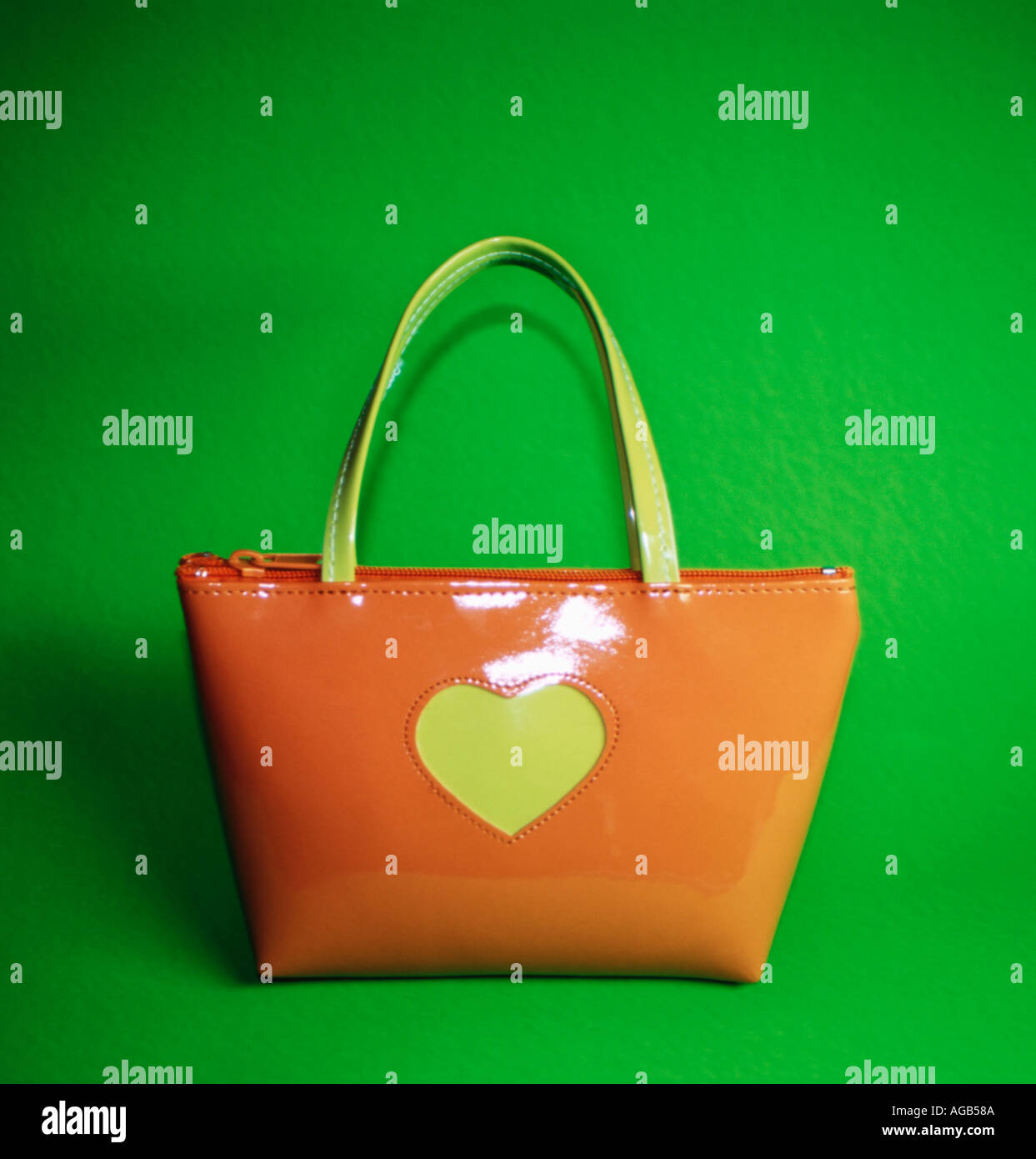 little cute orange purse on a green background Stock Photo - Alamy