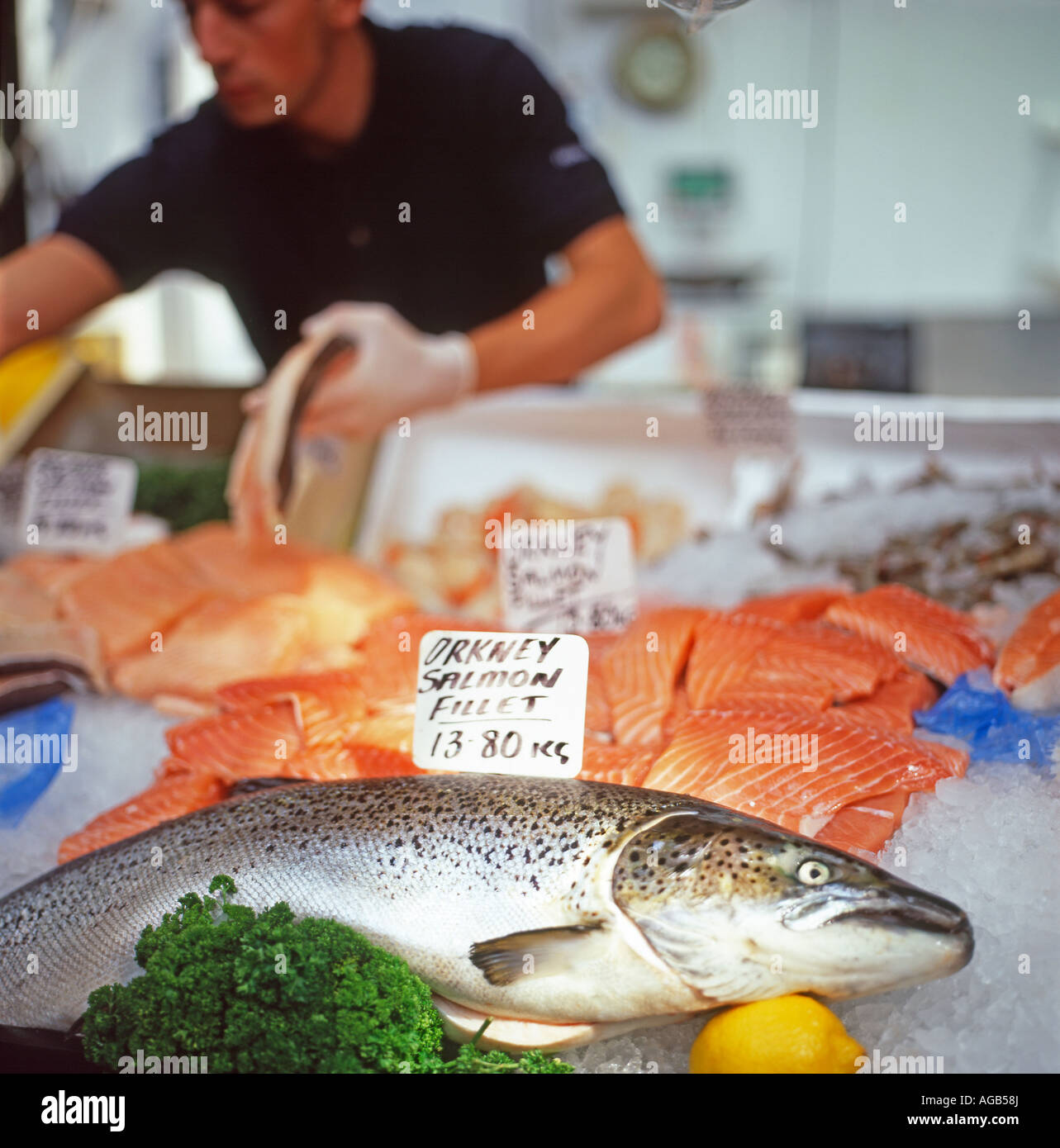 A market trader fish seller selling fresh Scottish Orkney salmon fillet ...