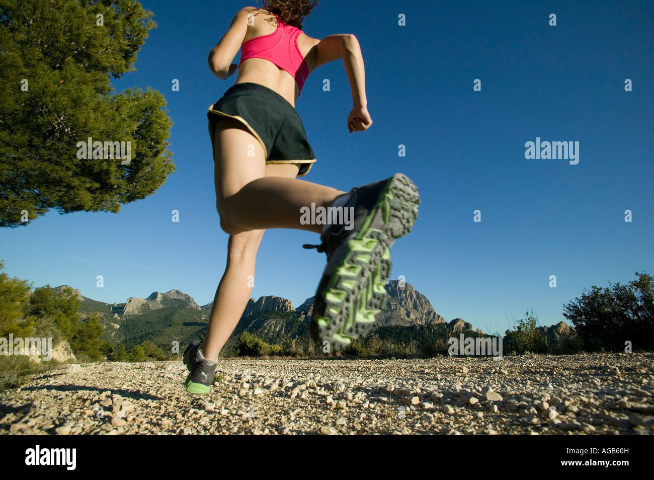 Female trail runner with mountain background Stock Photo - Alamy