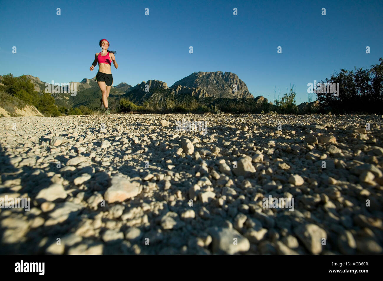 Female trail runner with mountain background Stock Photo - Alamy