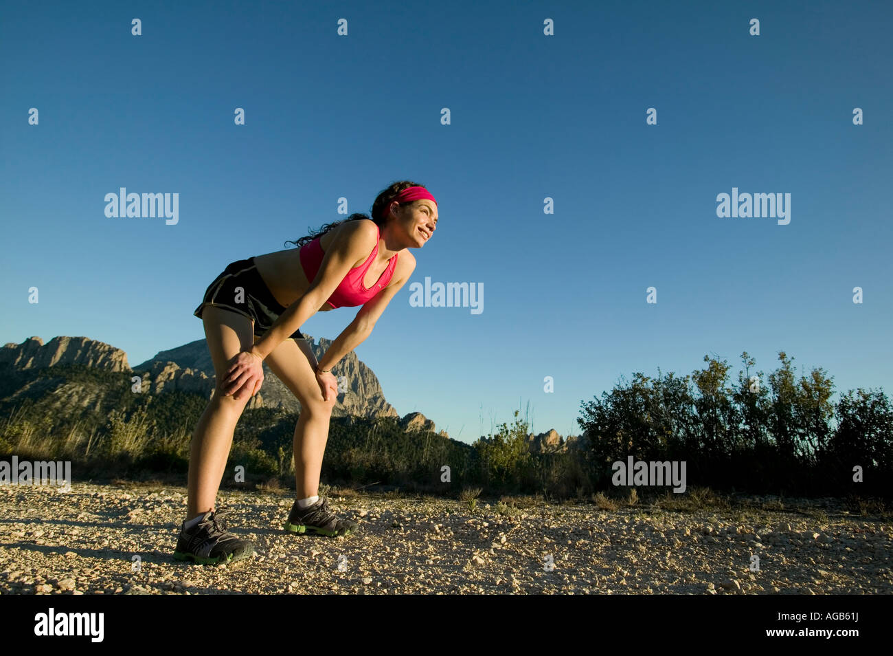 Exhausted female runner resting on trail Stock Photo - Alamy