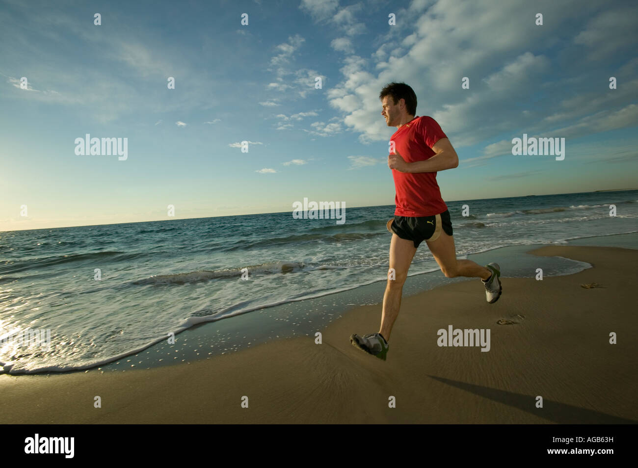 Male runner on beach Stock Photo - Alamy