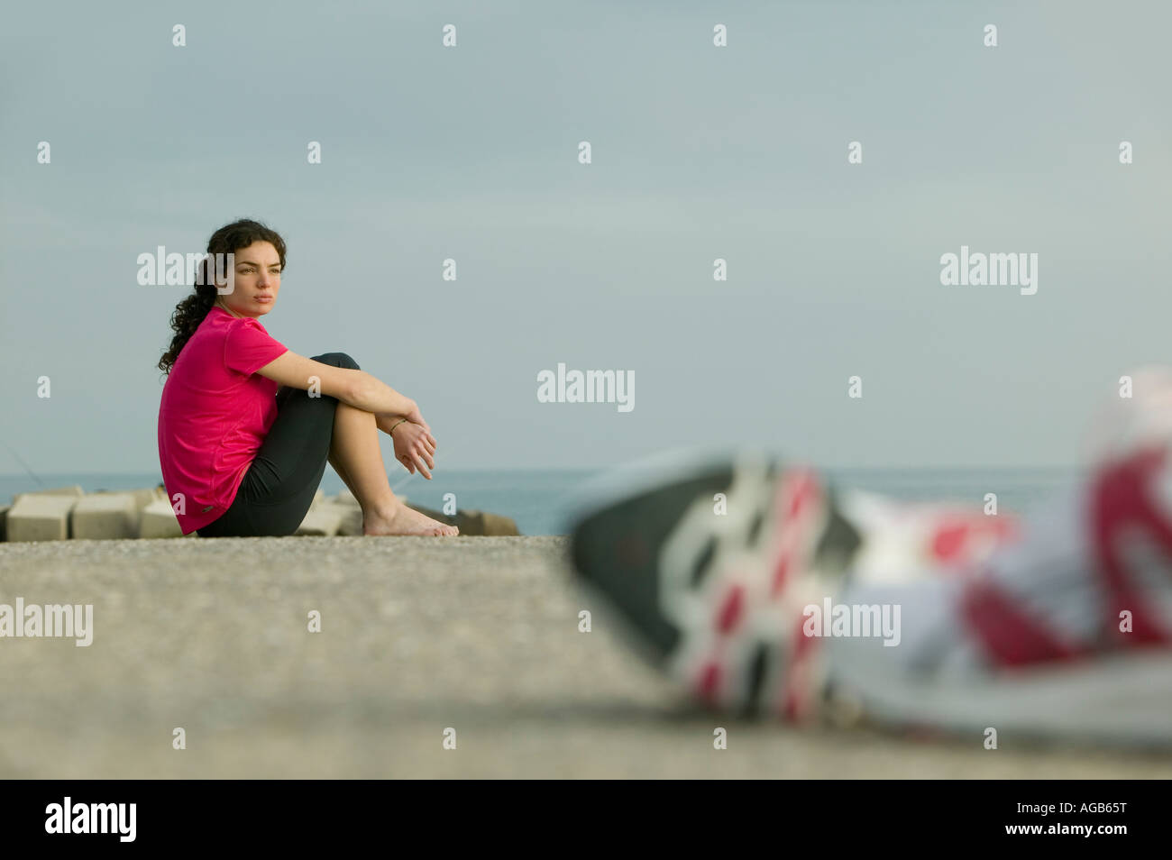 Female runner resting on concrete jetty Stock Photo - Alamy