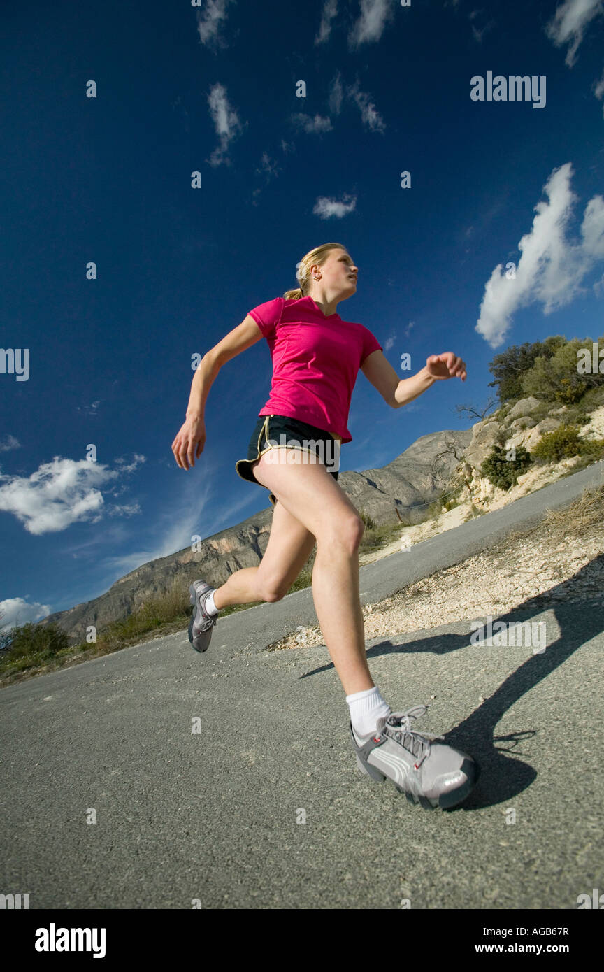 Female runner on scenic road Stock Photo - Alamy