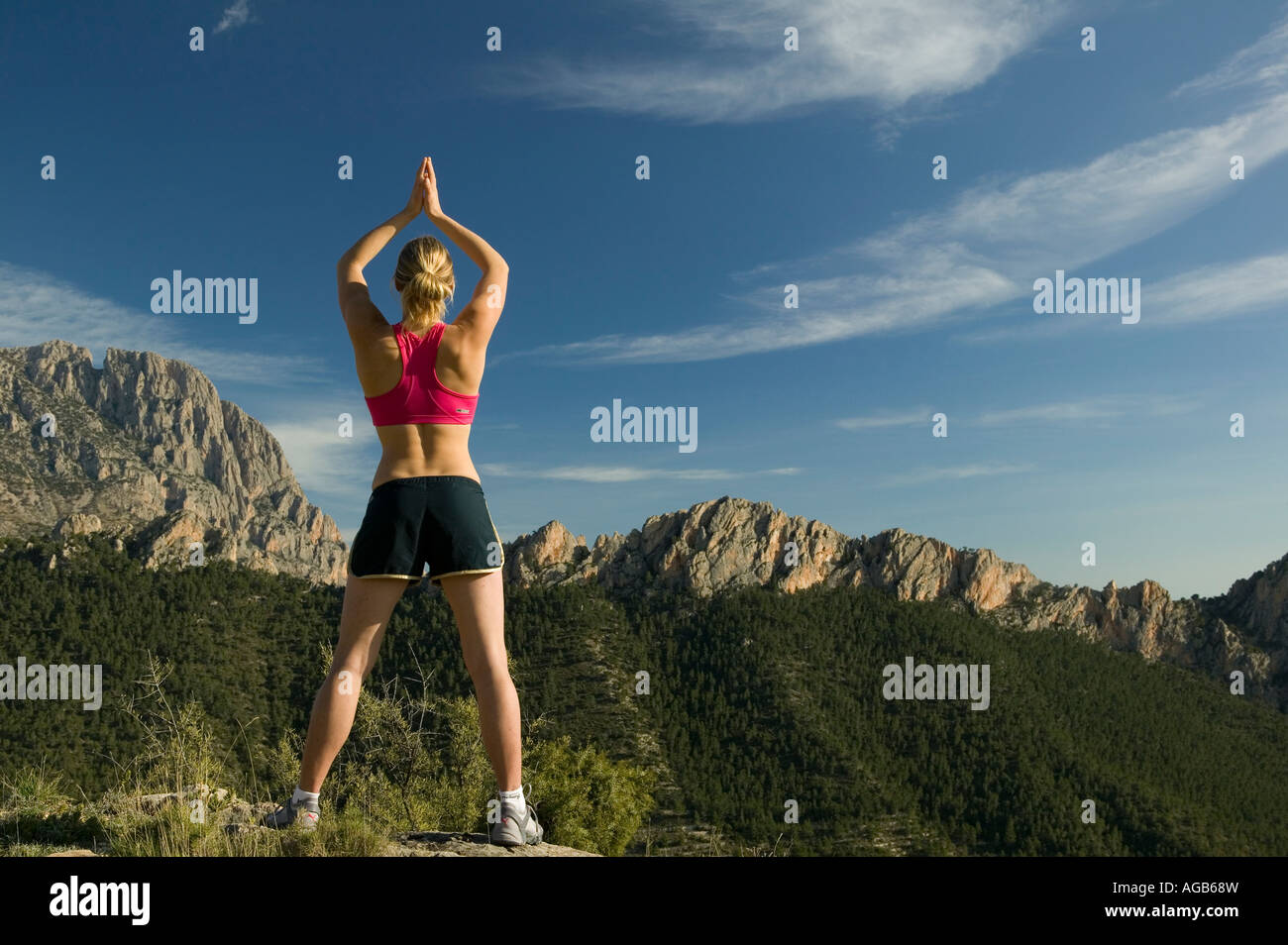 Female runner meditating with mountain background Stock Photo - Alamy
