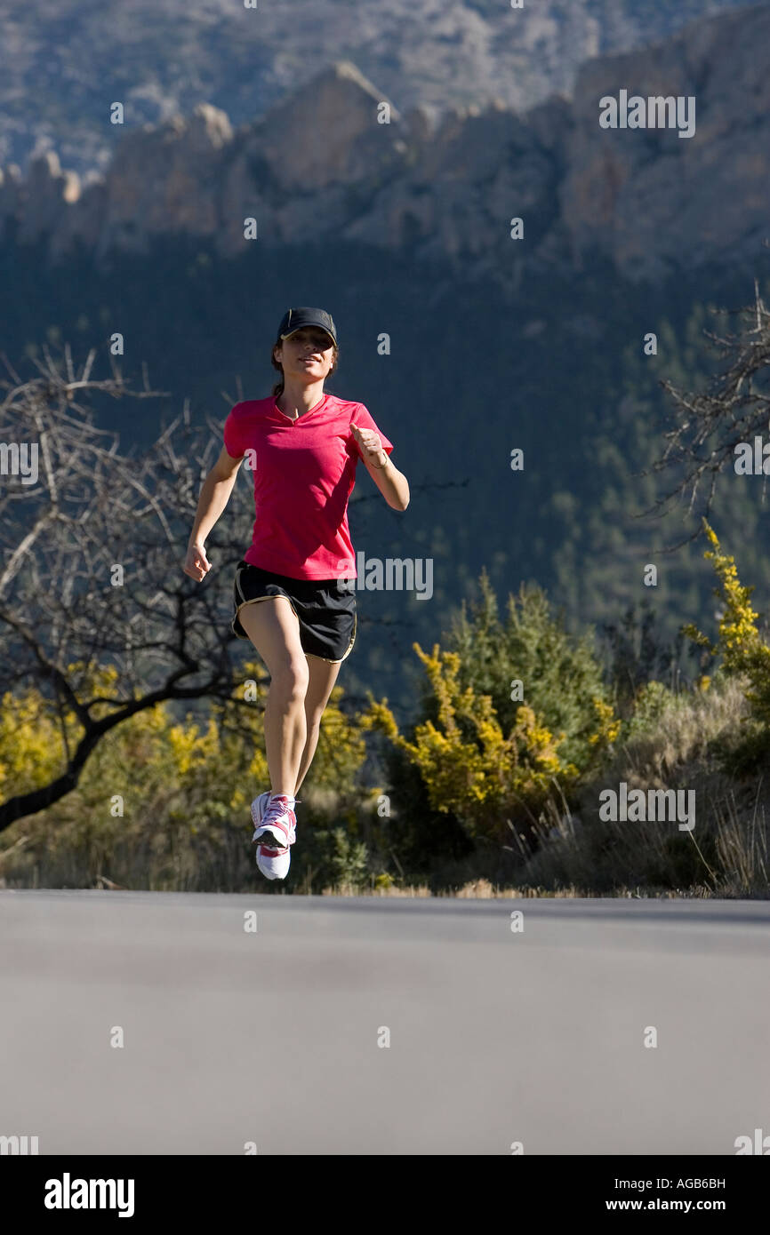 Female runner on mountain road Stock Photo - Alamy