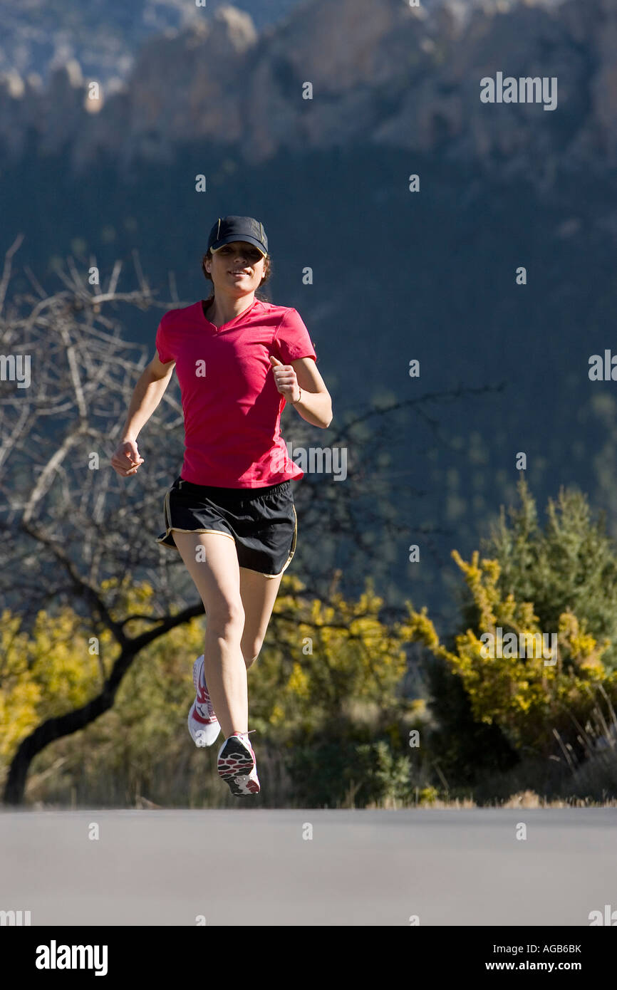 Female runner on mountain road Stock Photo - Alamy