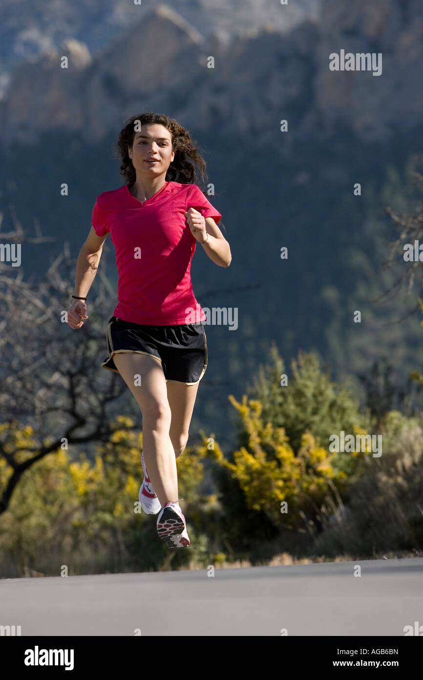 Female runner on mountain road Stock Photo - Alamy