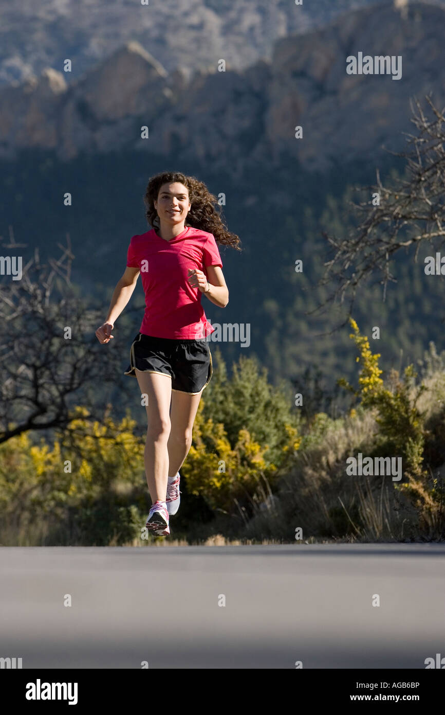 Female runner on mountain road Stock Photo - Alamy