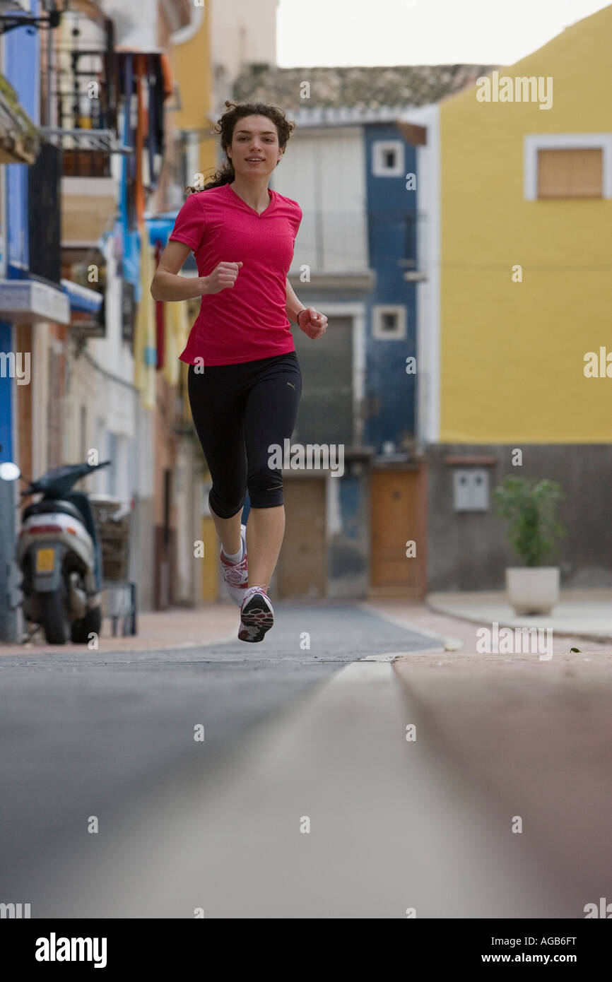 Female running in town Stock Photo - Alamy