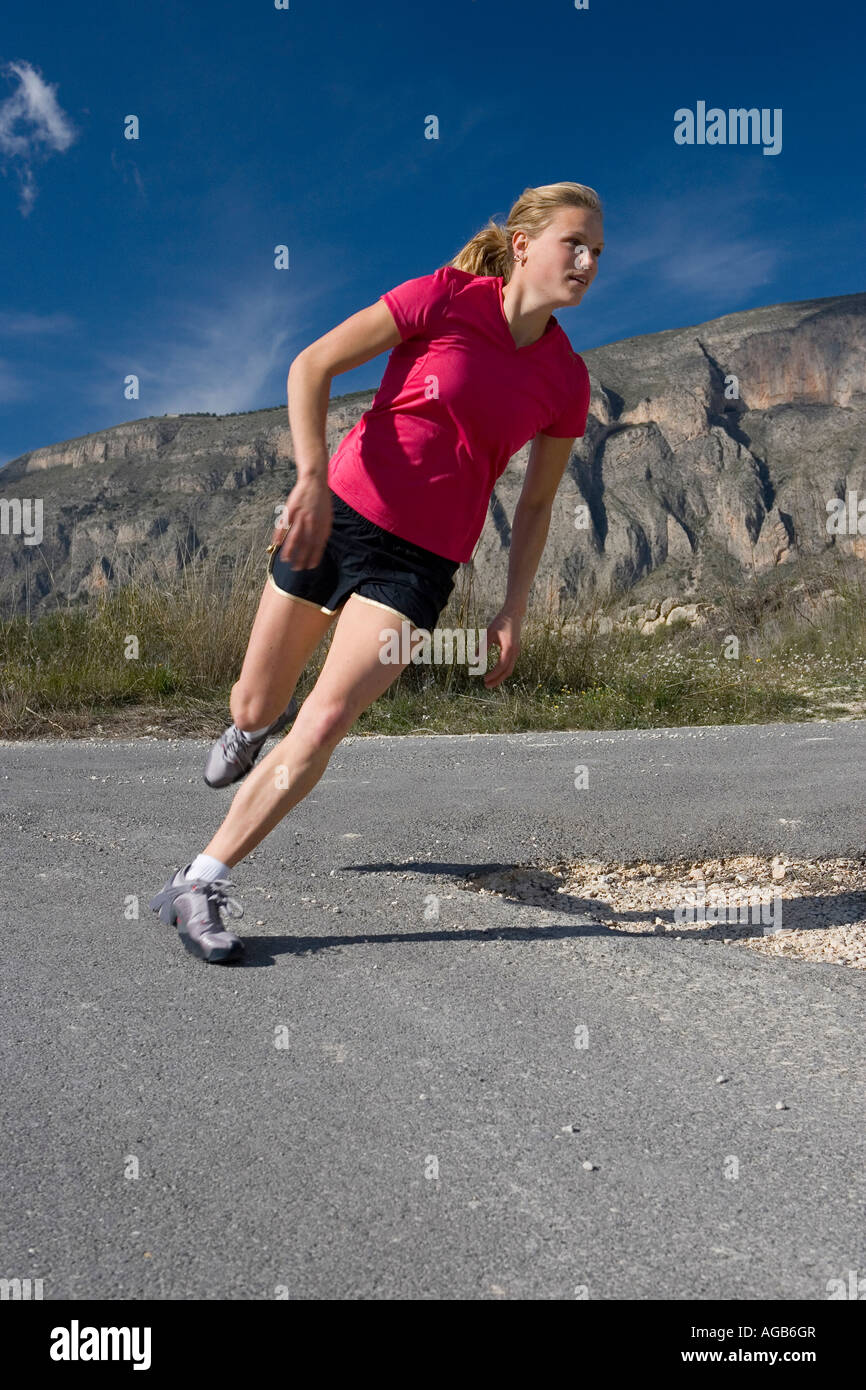 Female runner on mountain road Stock Photo - Alamy