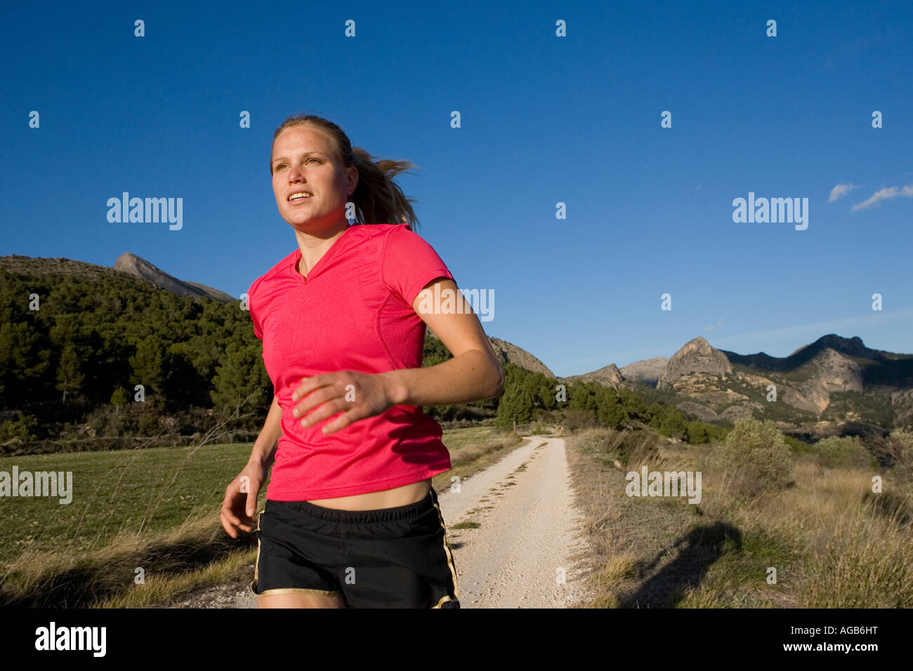 Female runner on mountain trail Stock Photo - Alamy