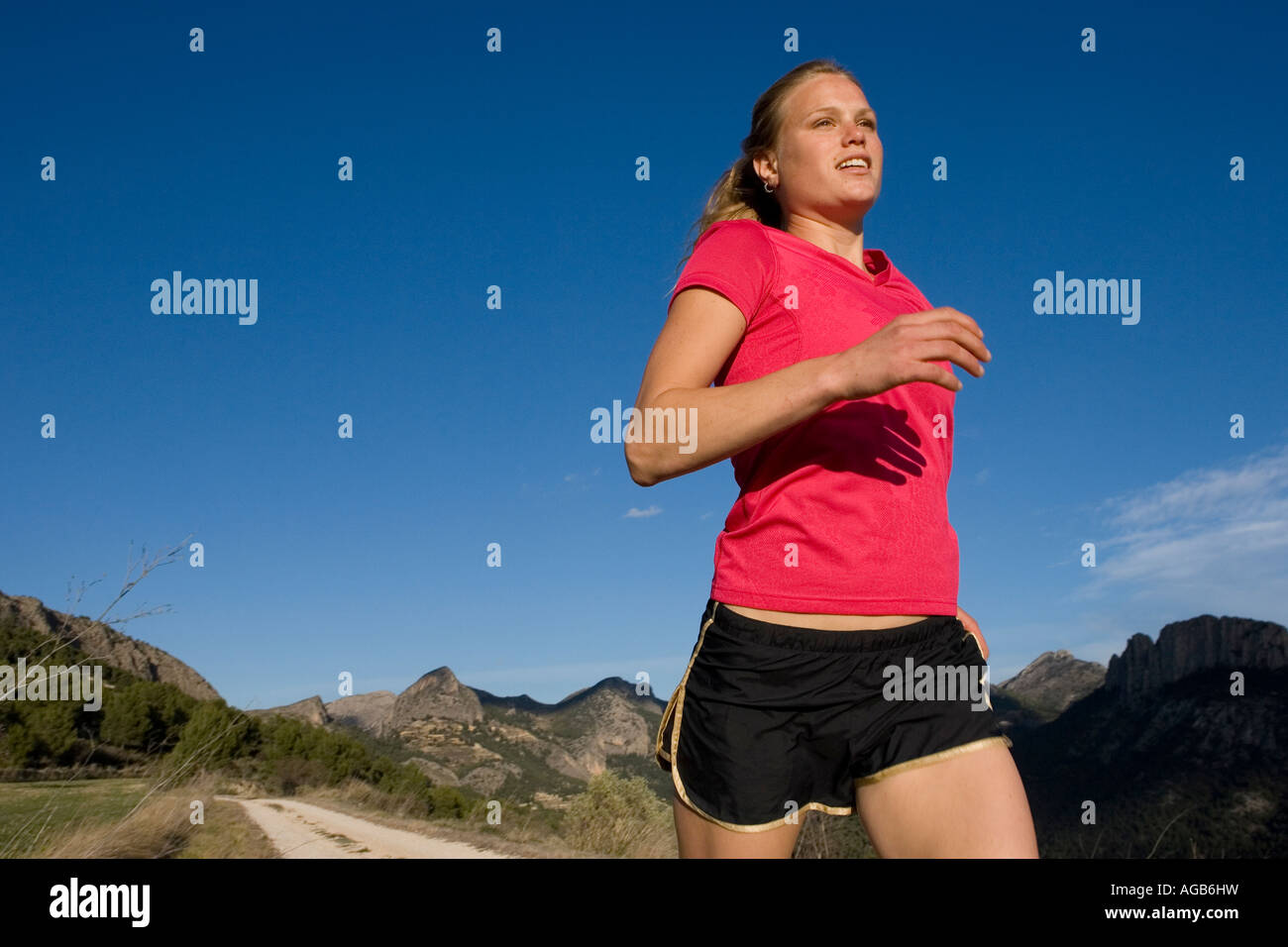Female runner on mountain trail Stock Photo - Alamy