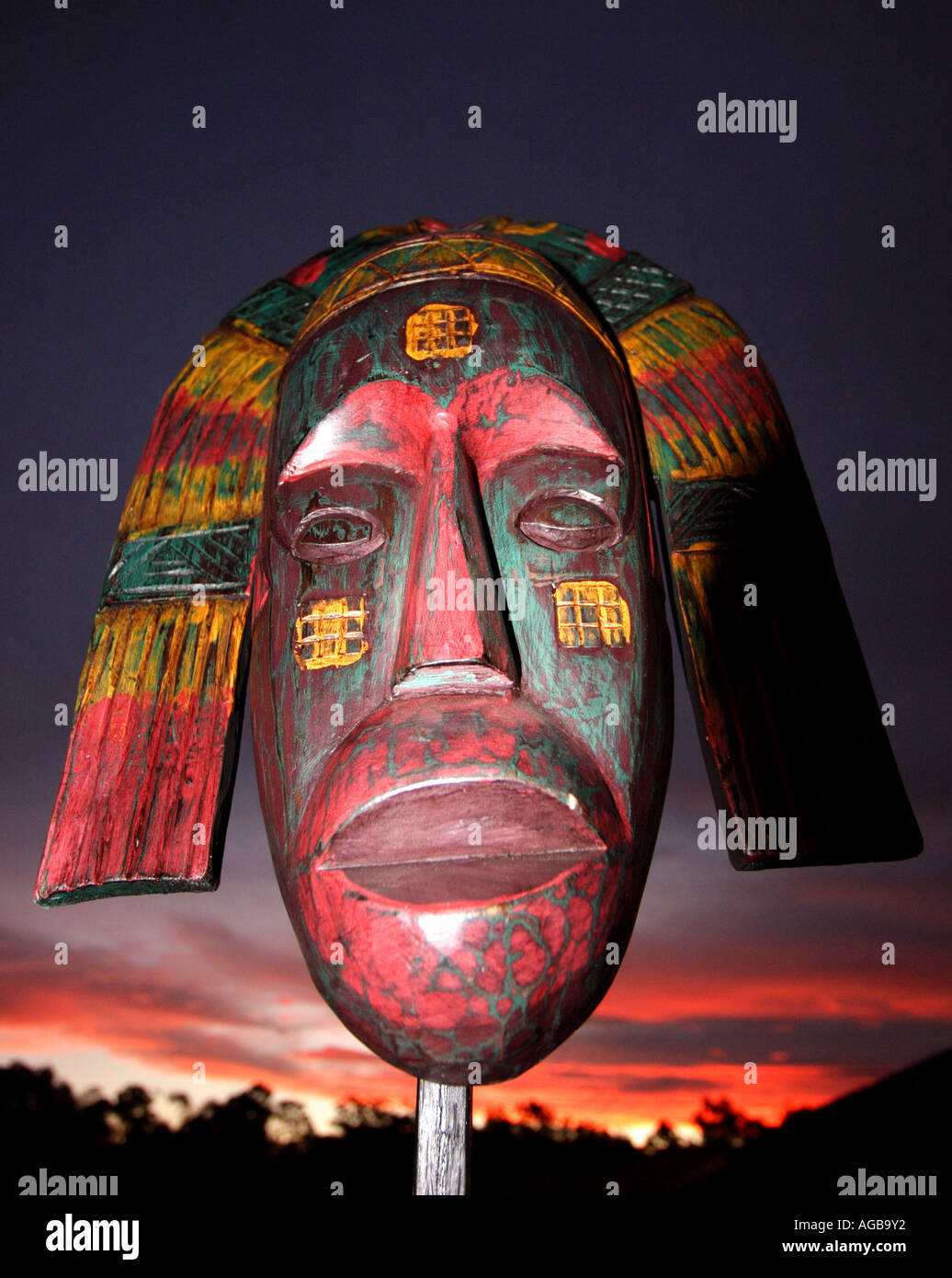 HAND CARVED WOODEN MASK AGAINST A RED SUNSET SKY VERTICAL BAPDB8175 ...