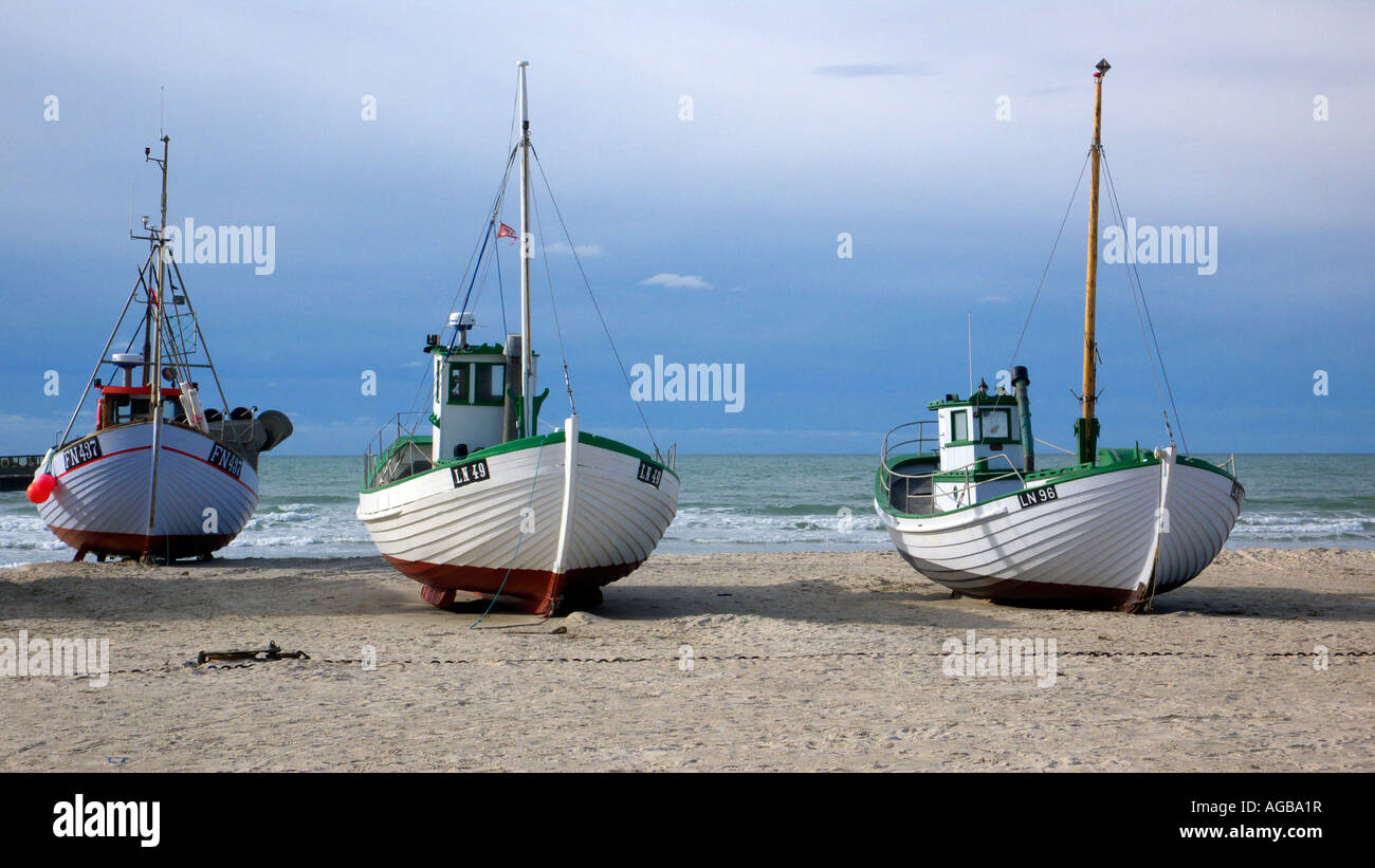 Three Danish fishing boats beached on the sand at the sea side in ...