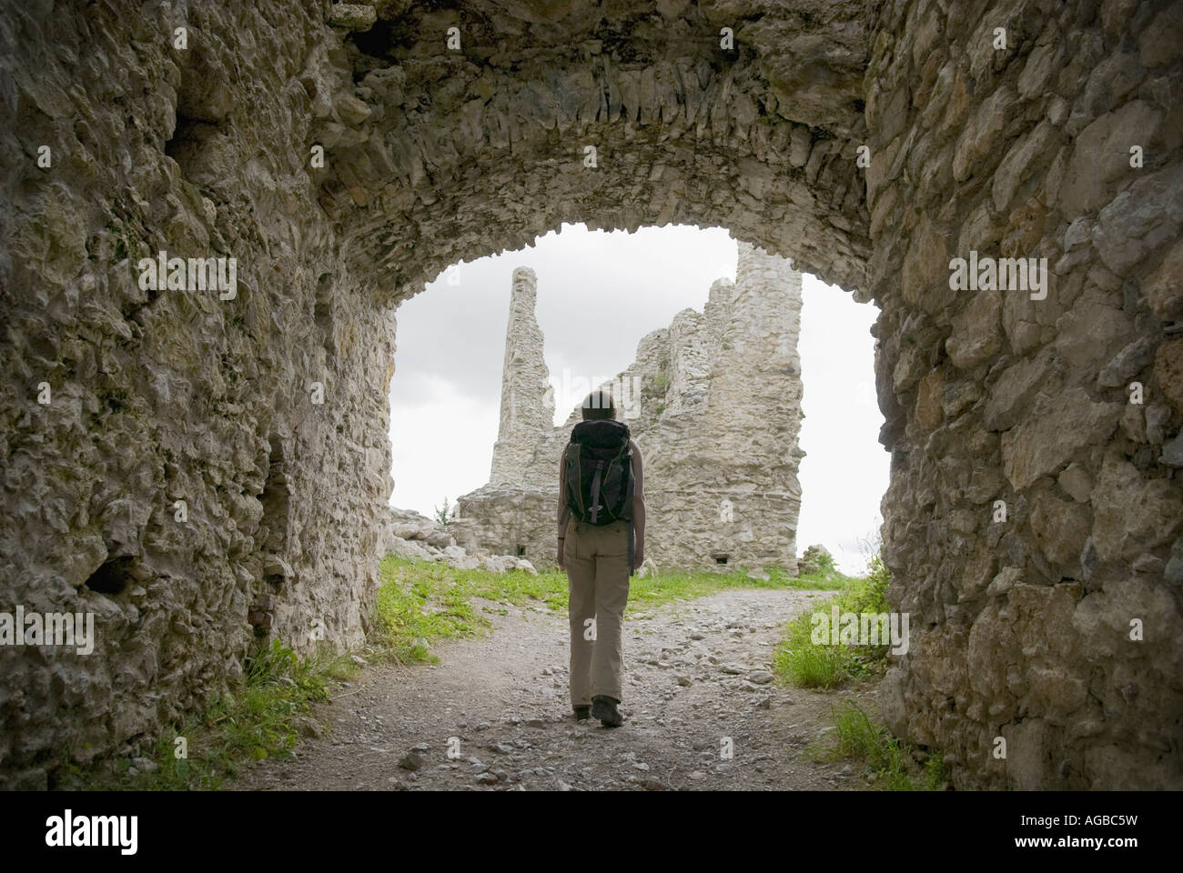 single female tourist walks through entrance of German castle ruin of ...