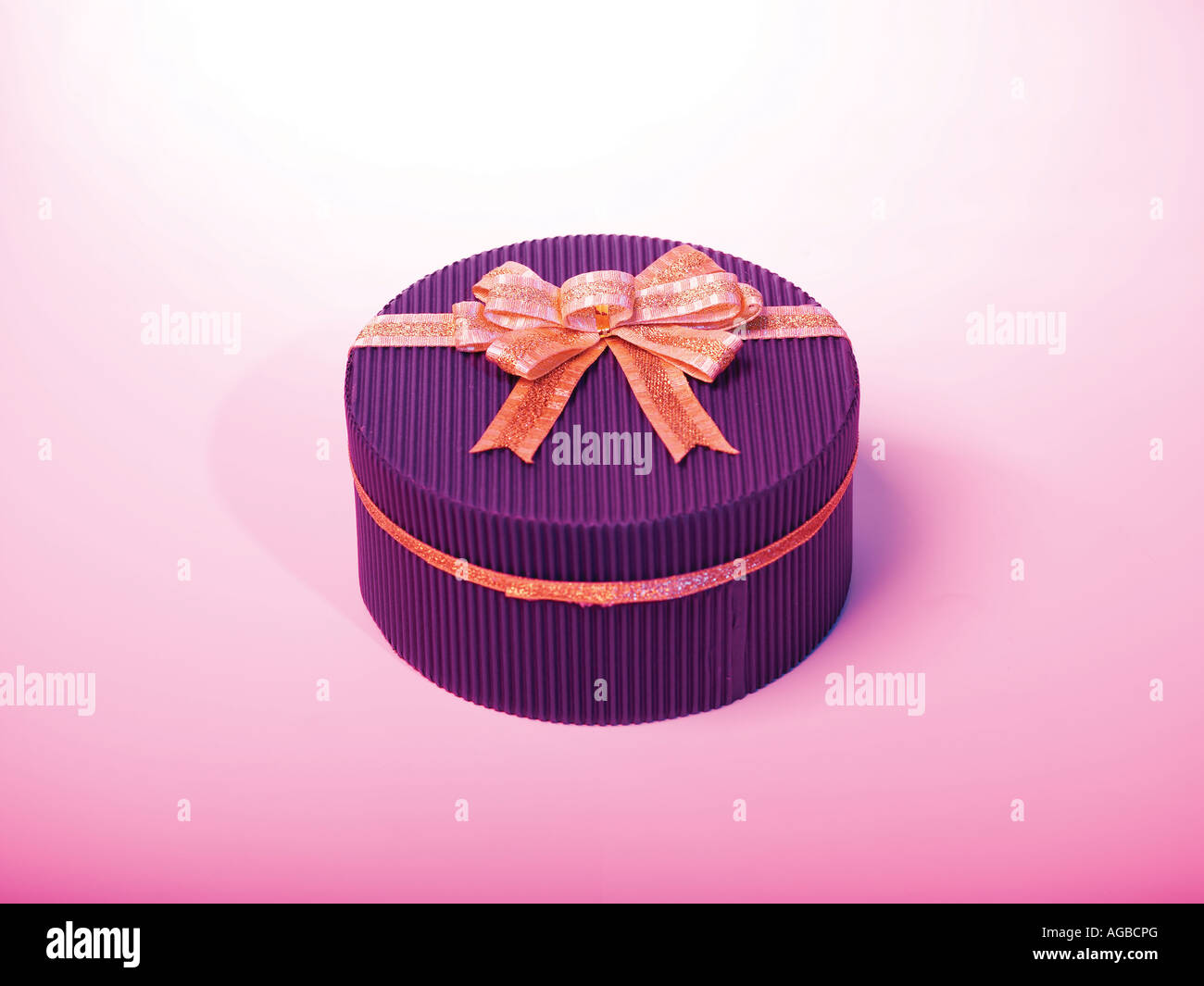 Round shaped box with golden bow, elevated view Stock Photo - Alamy