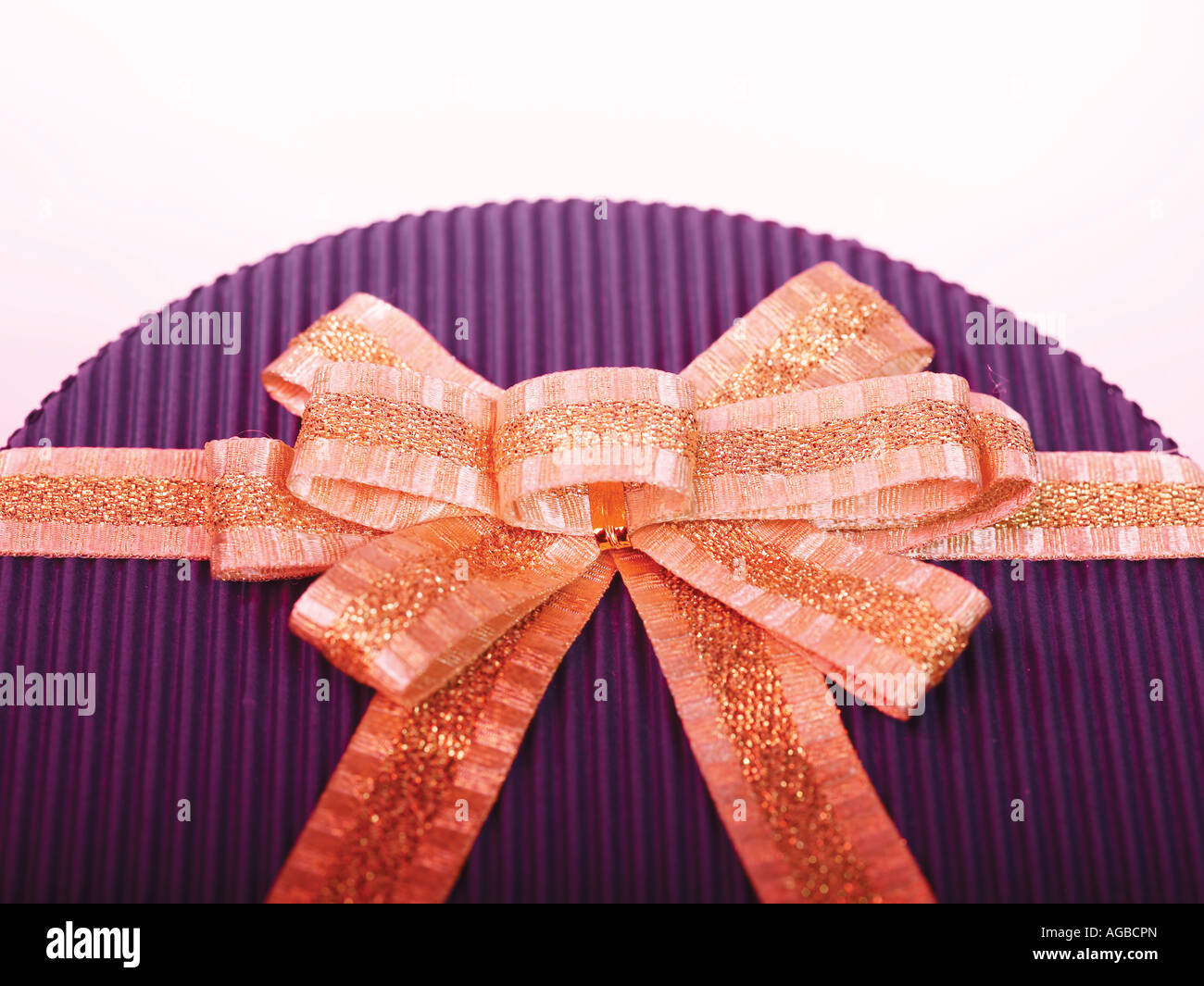 Round shaped box with golden bow, Close-up Stock Photo - Alamy