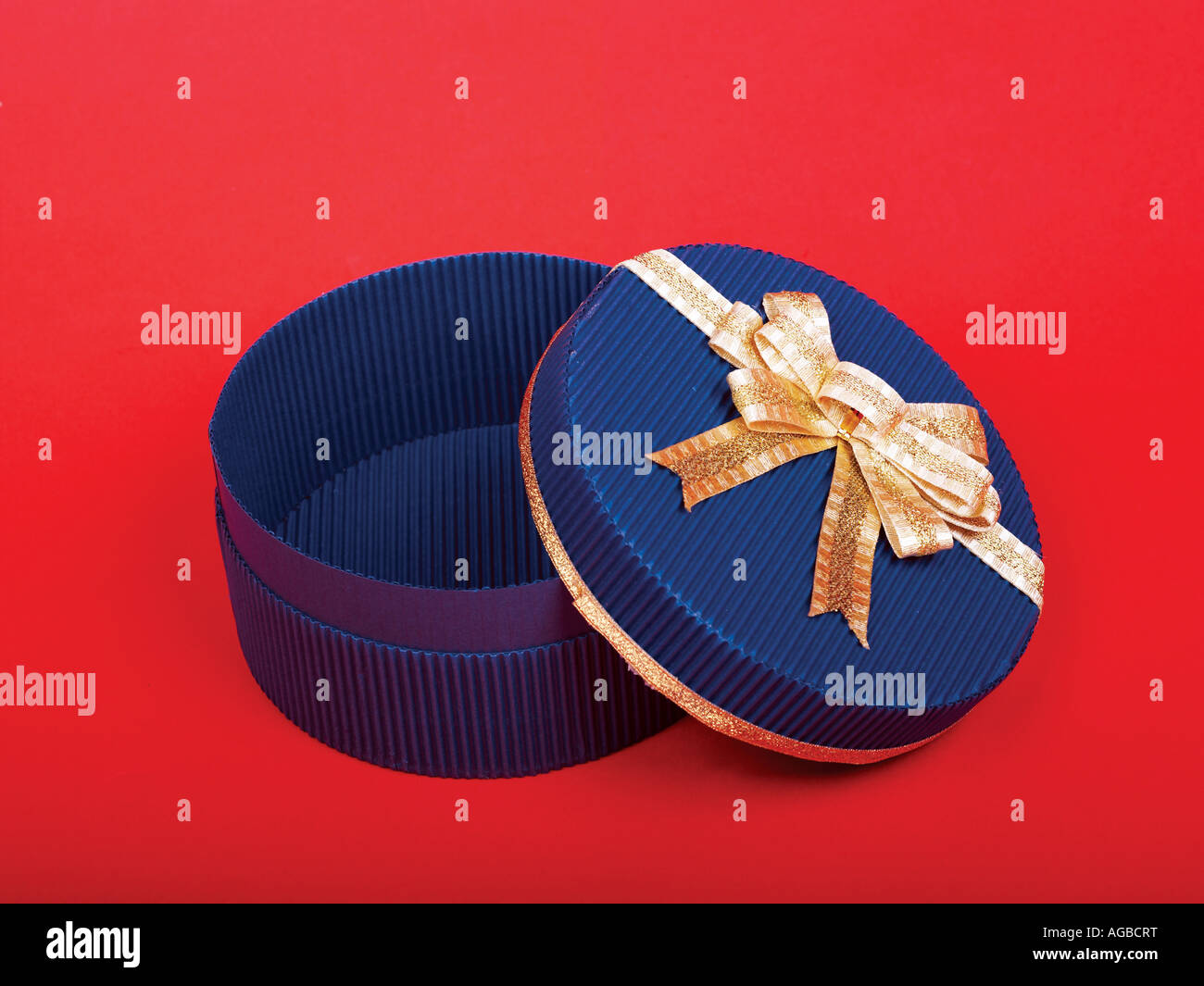 Round shaped box with golden bow, elevated view Stock Photo - Alamy