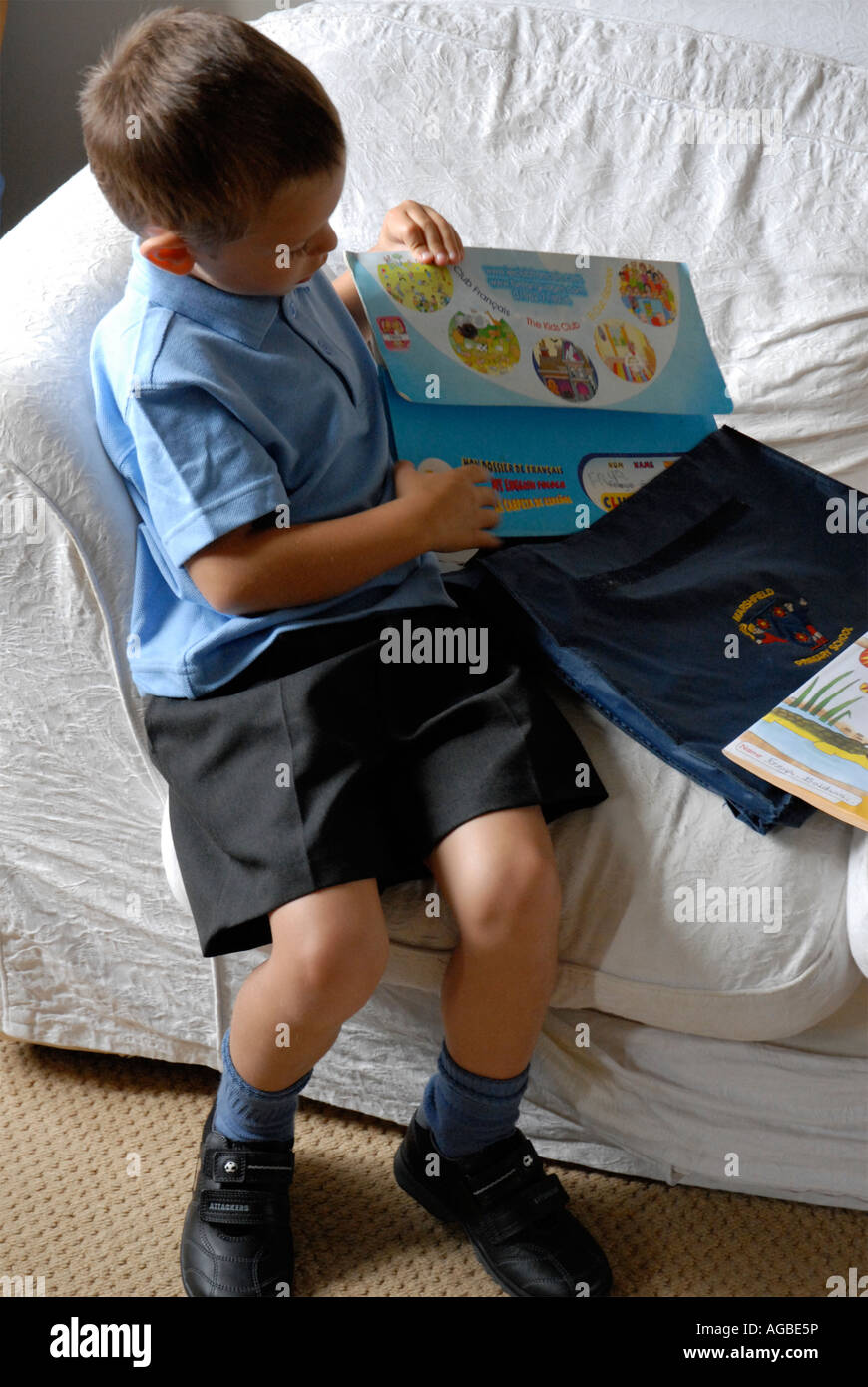 Little boy putting books inside his book bag Stock Photo - Alamy