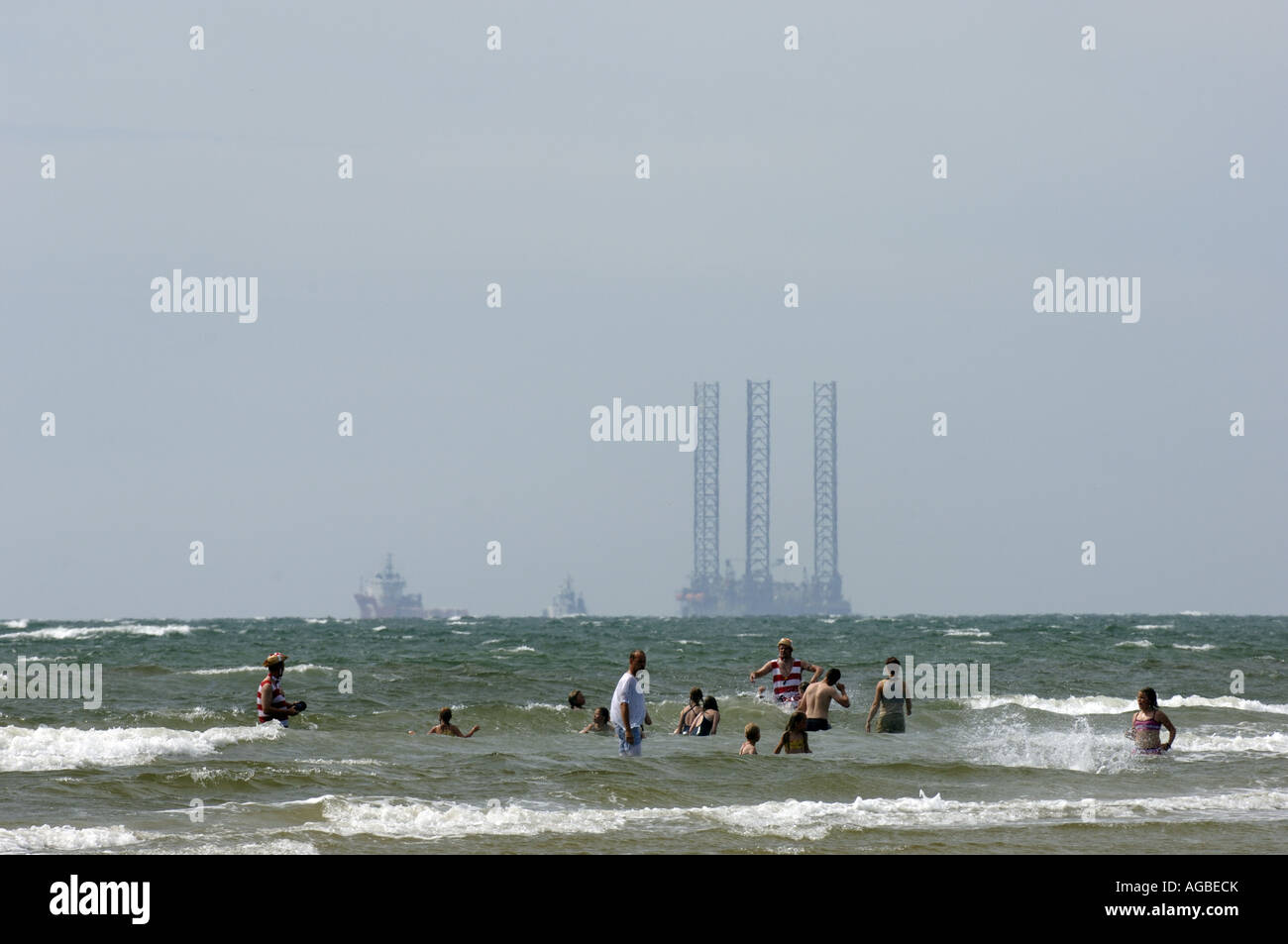 Denmark Fano group of tourist swimming while an oil platform is towed ...